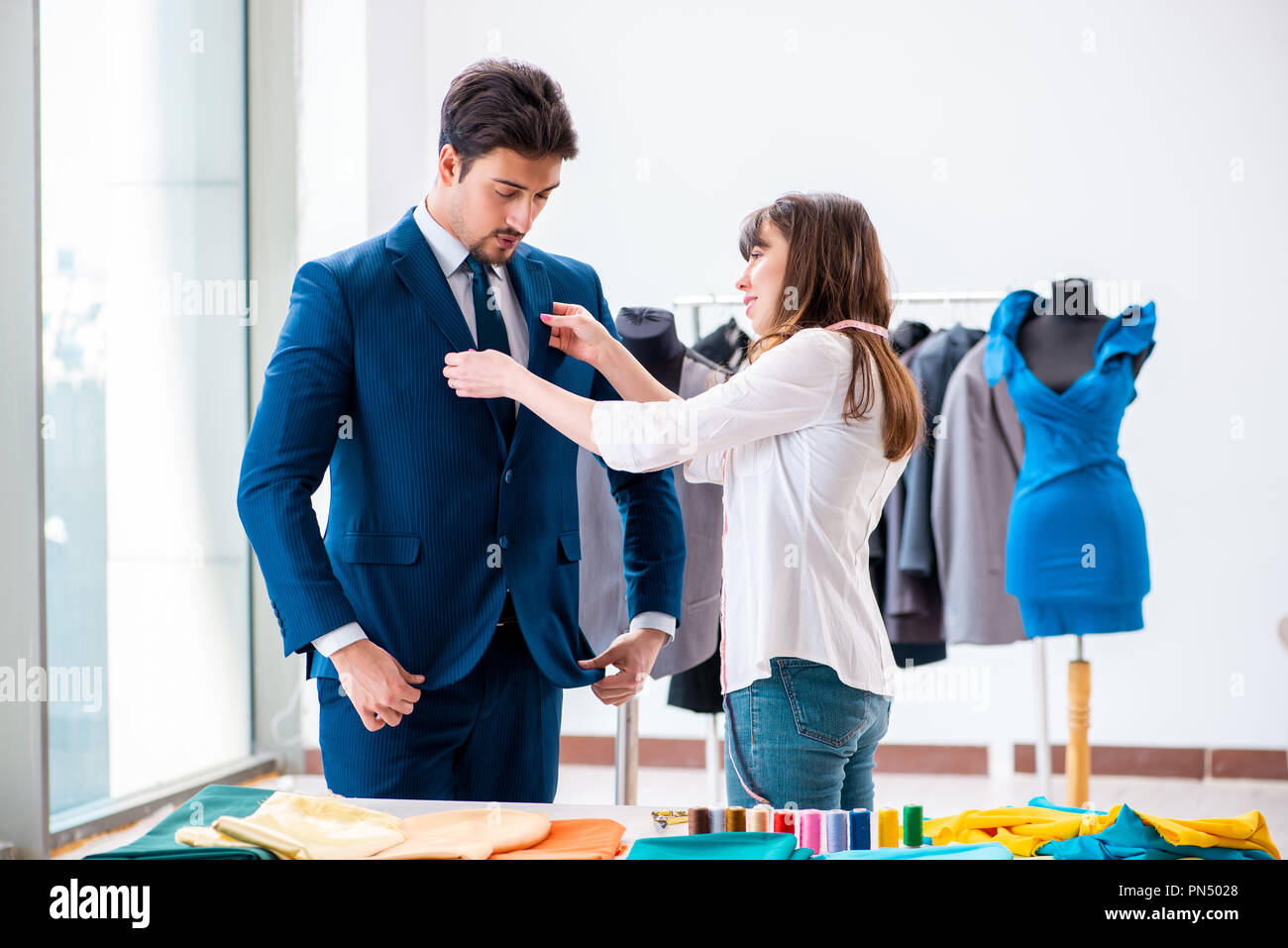 Professional tailor taking measurements for formal suit Stock Photo - Alamy