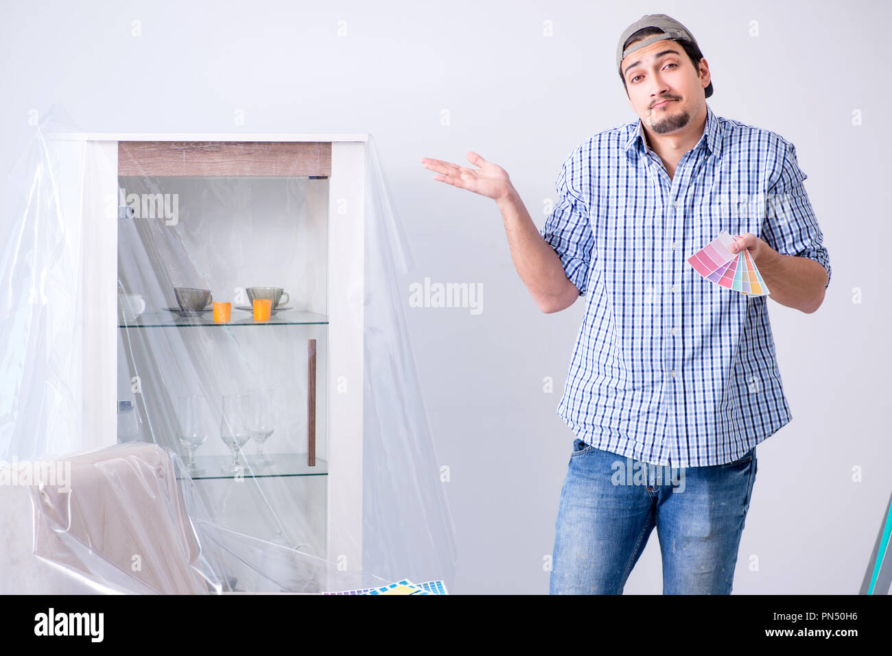 Young man contractor choosing color from rainbow Stock Photo - Alamy