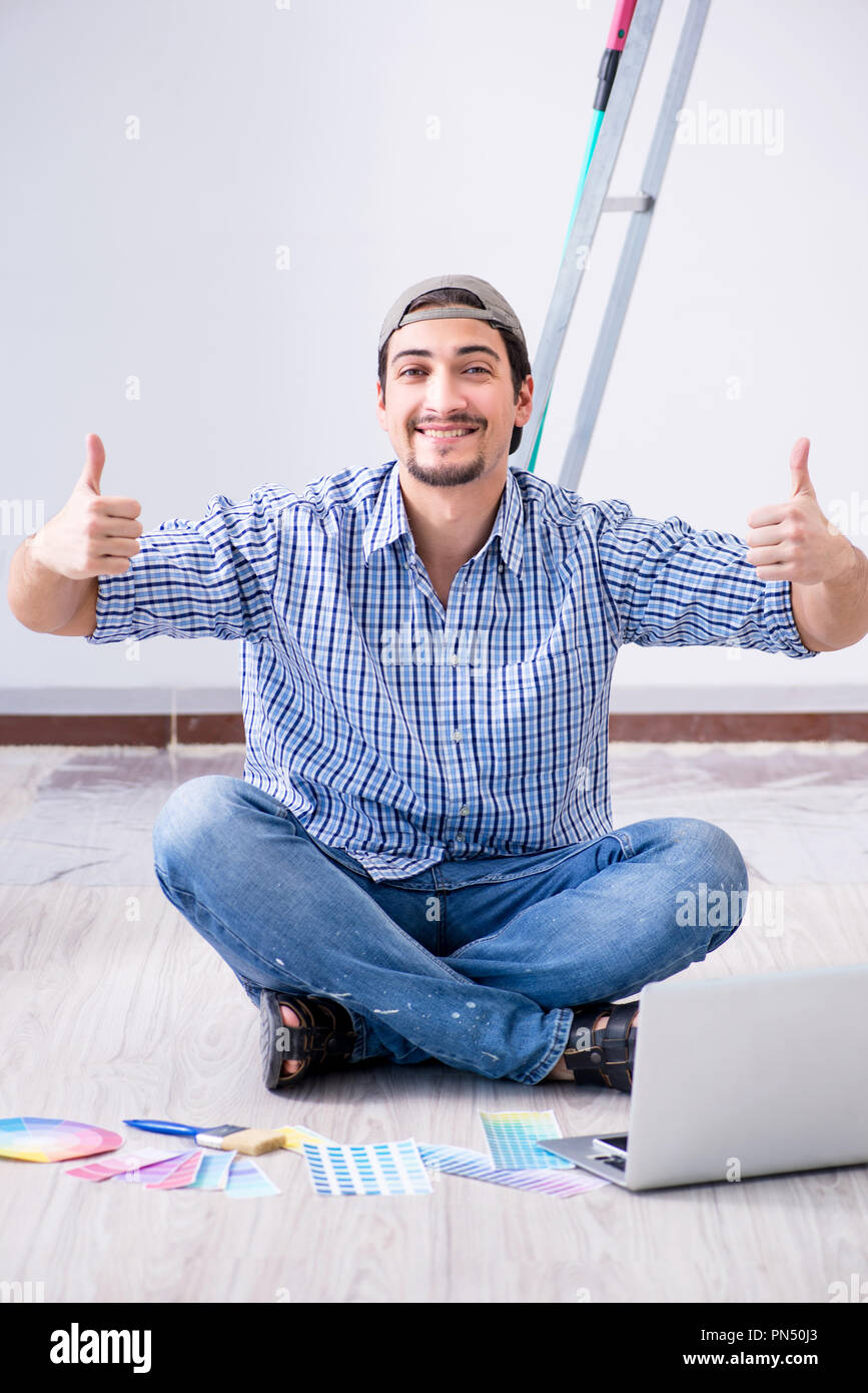 Young man contractor choosing color from rainbow Stock Photo - Alamy