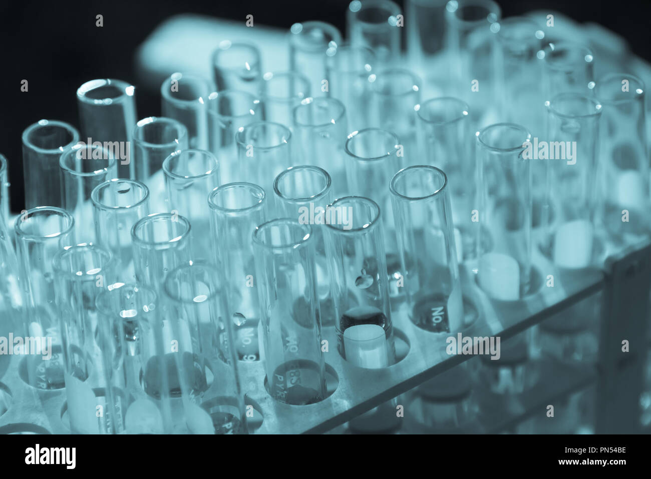 Lab science research glass items adding drop to one of several test ...