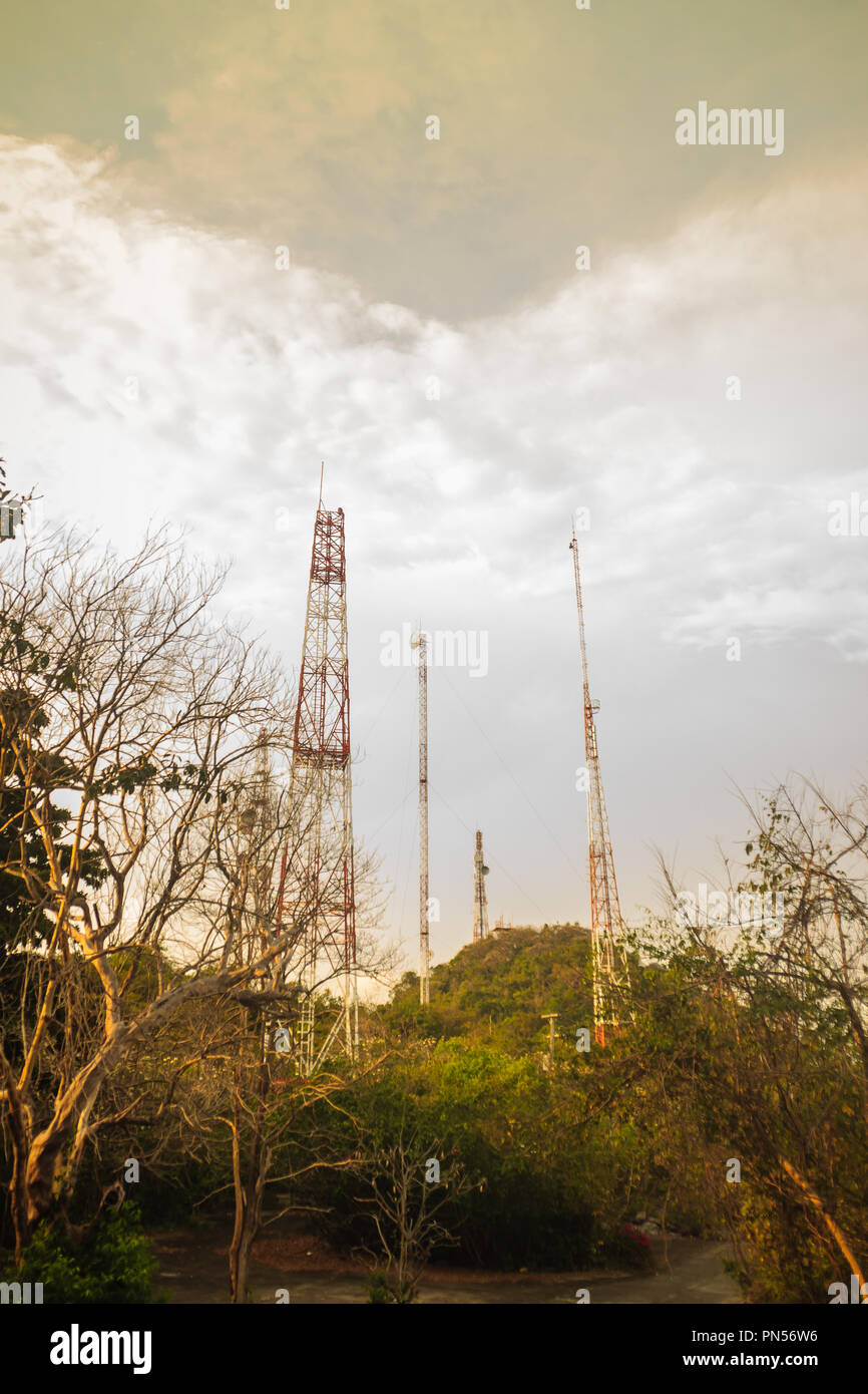 Telecommunication towers on the summit of the hill under cloudy blue ...