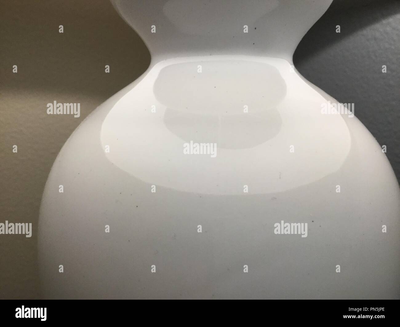 White reflective ceramic object in corner with two tones Stock Photo ...