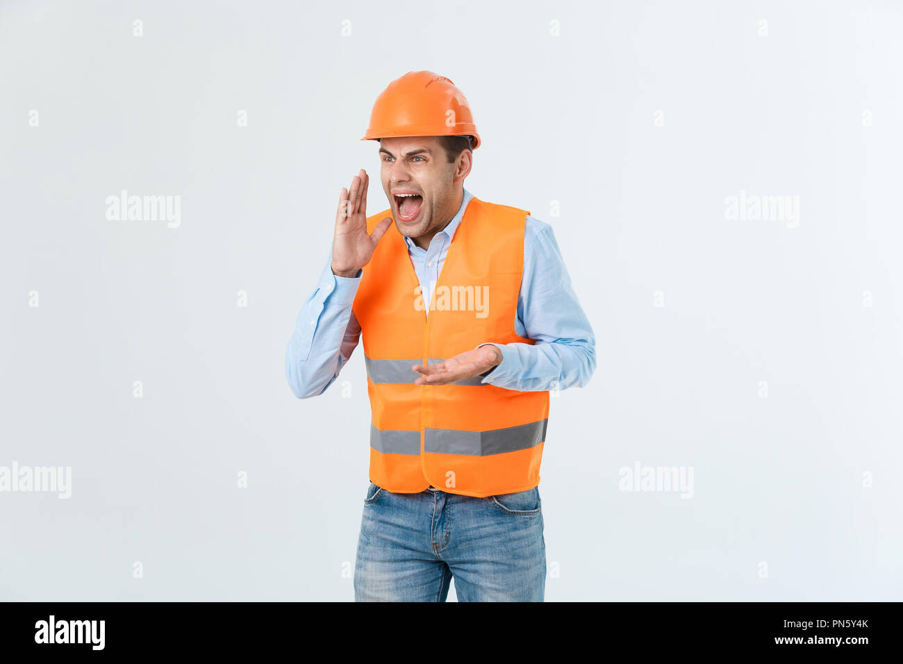 Handsome young engineer man over white background wearing safety helmet ...