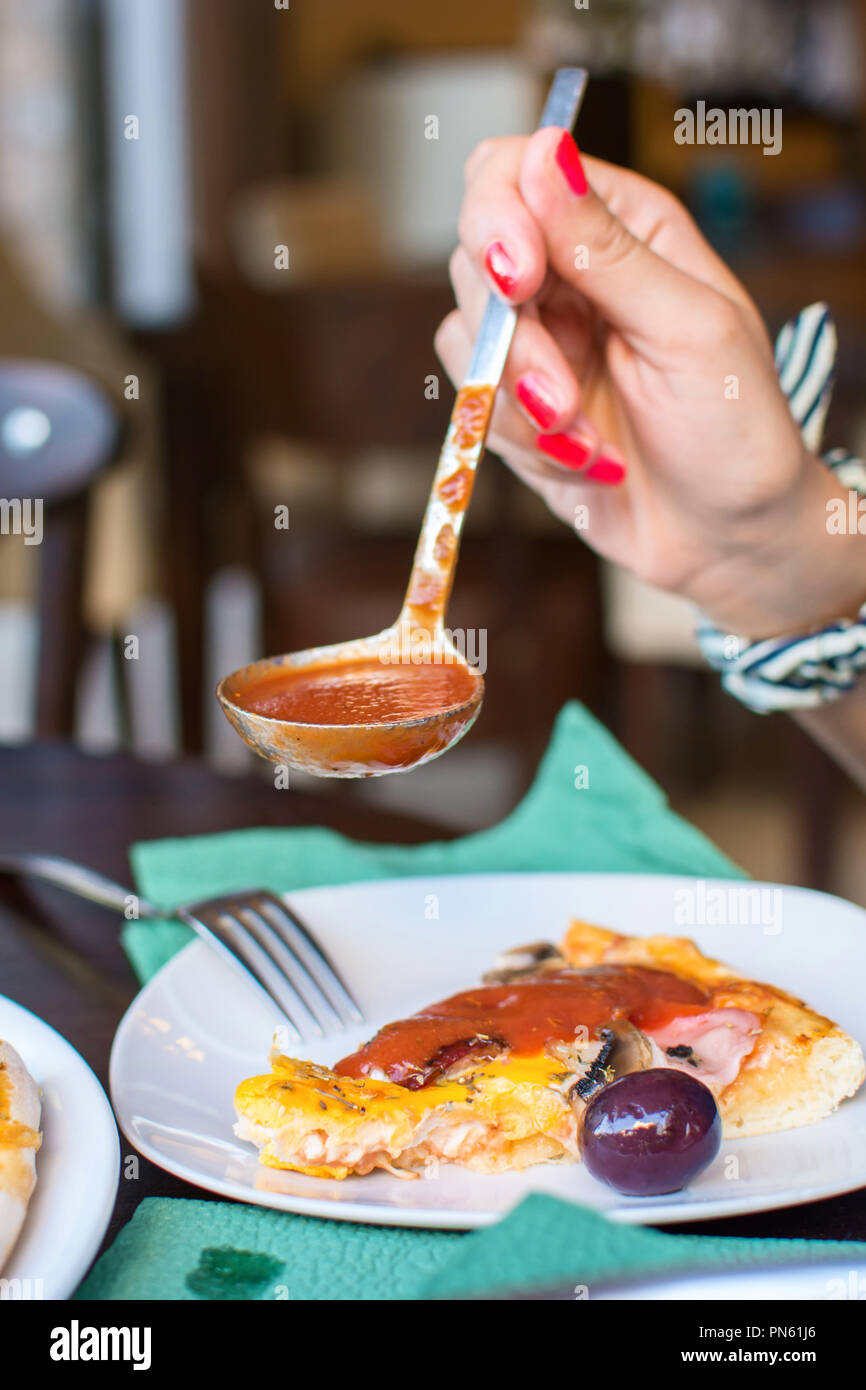 putting ketchup on pizza slice at the restaurant Stock Photo - Alamy