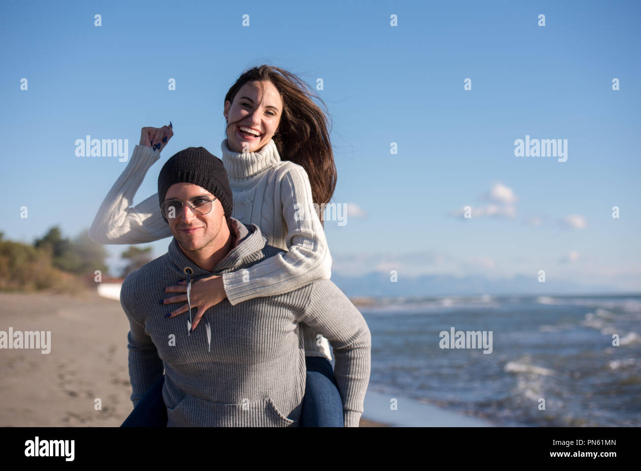Men Giving Piggy Back Rides his girlfriend At Sunset By The Sea, autumn time Stock Photo - Alamy