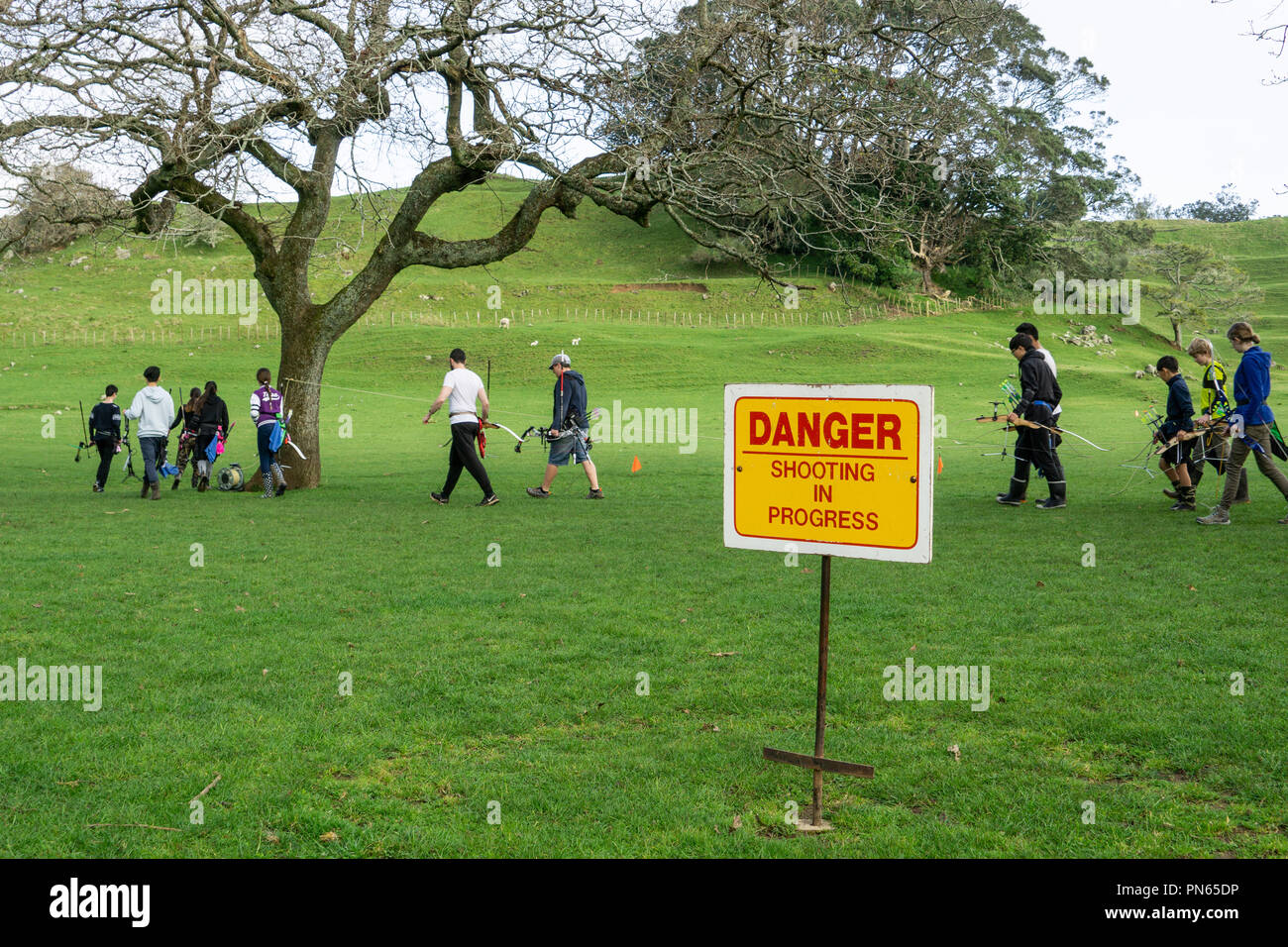 Warning sign Danger Shooting in Progress in front of group of archers ...