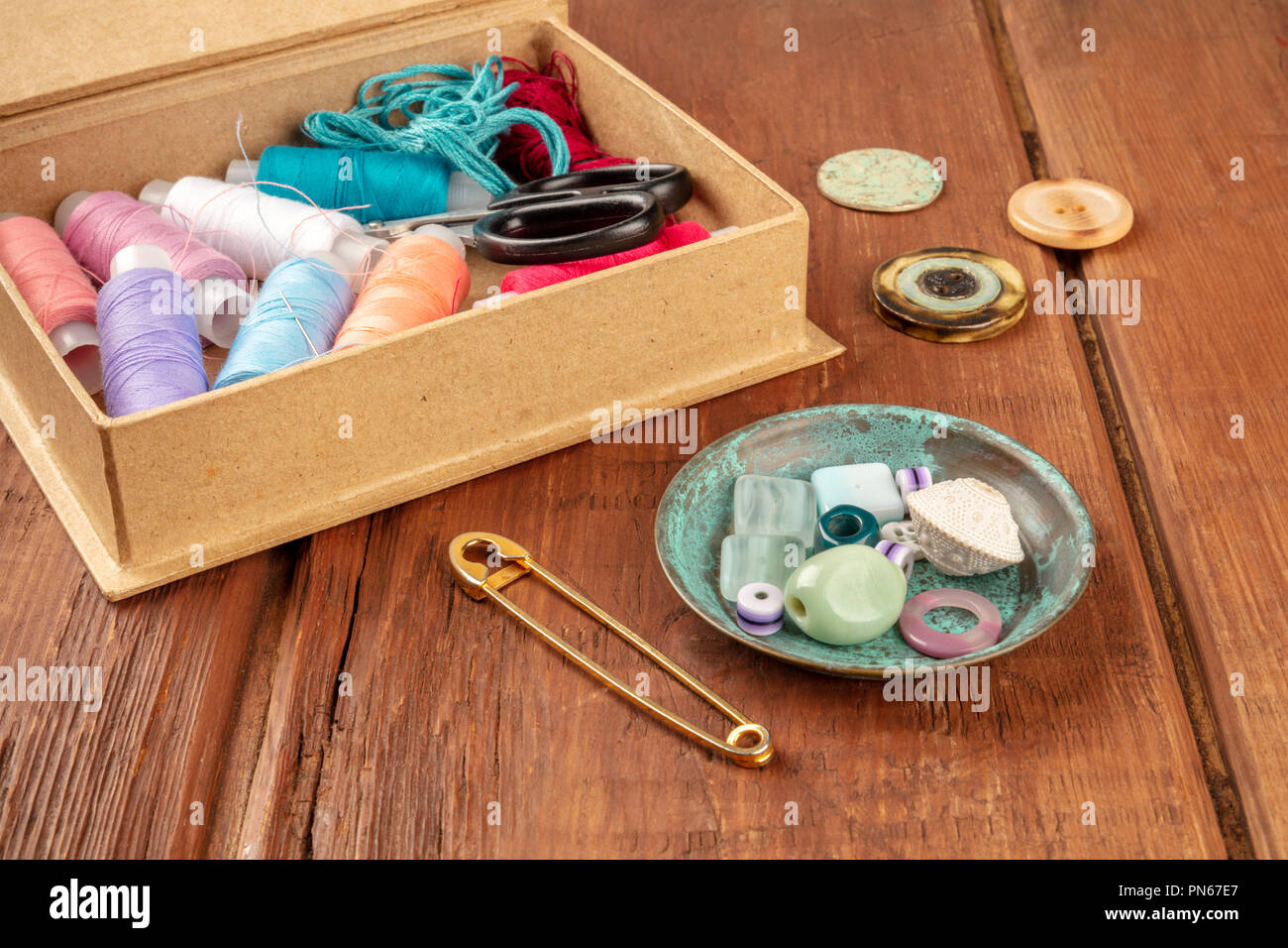 A photo of a sewing box with threads and scissors, with a vintage pin ...