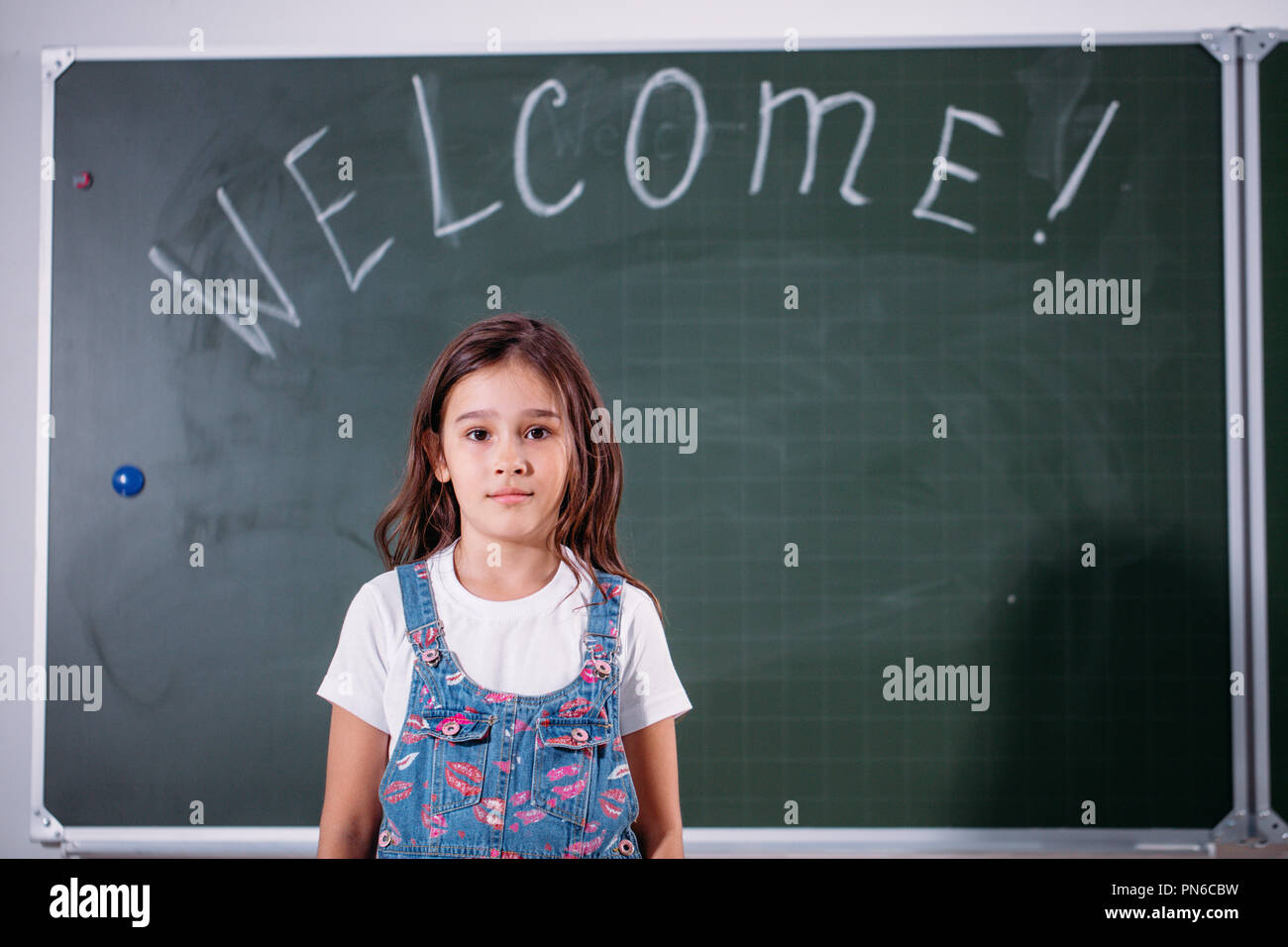sad tired schoolgirl on board background with welcome word Stock Photo ...