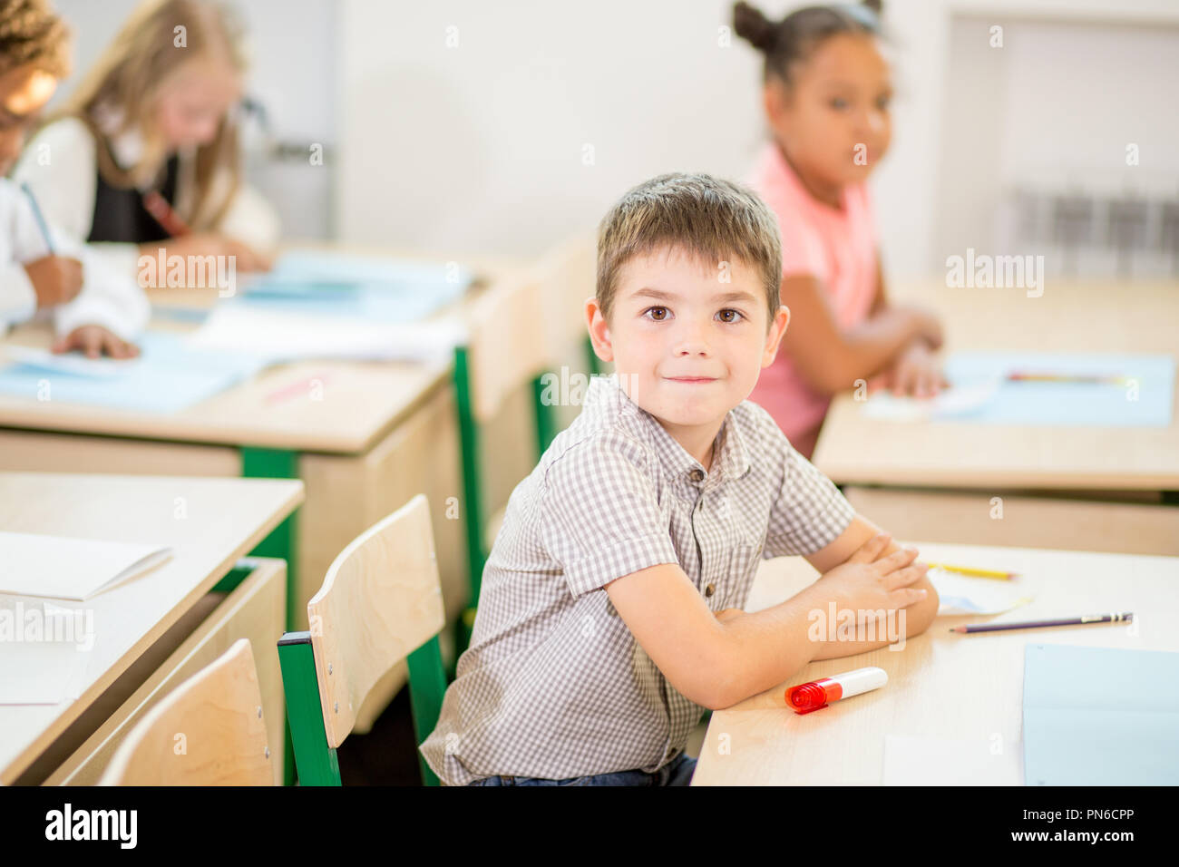 schoolboy in classroom. other students on background Stock Photo - Alamy