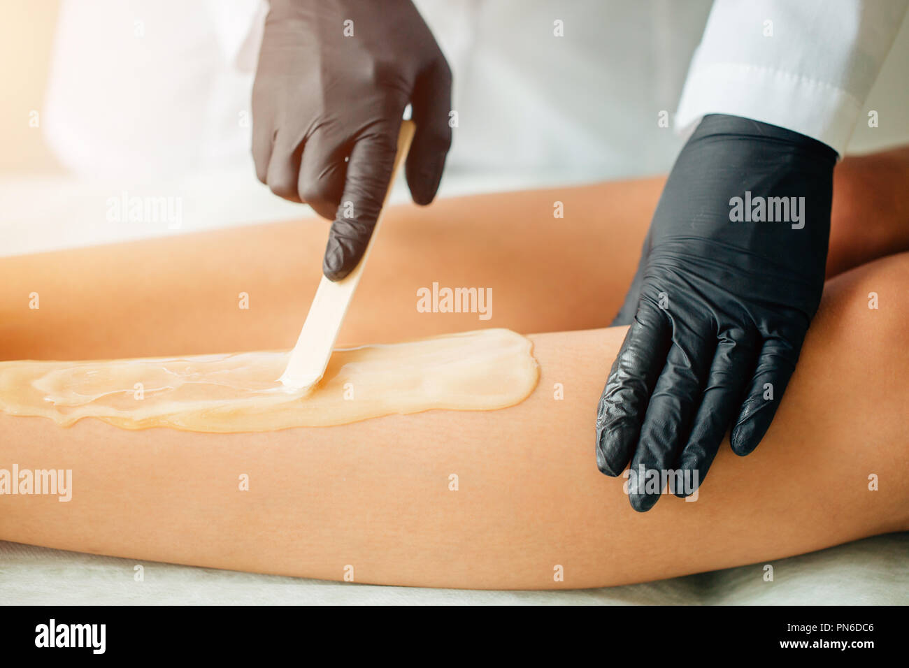 close up Young woman waxing her client lower leg Stock Photo - Alamy