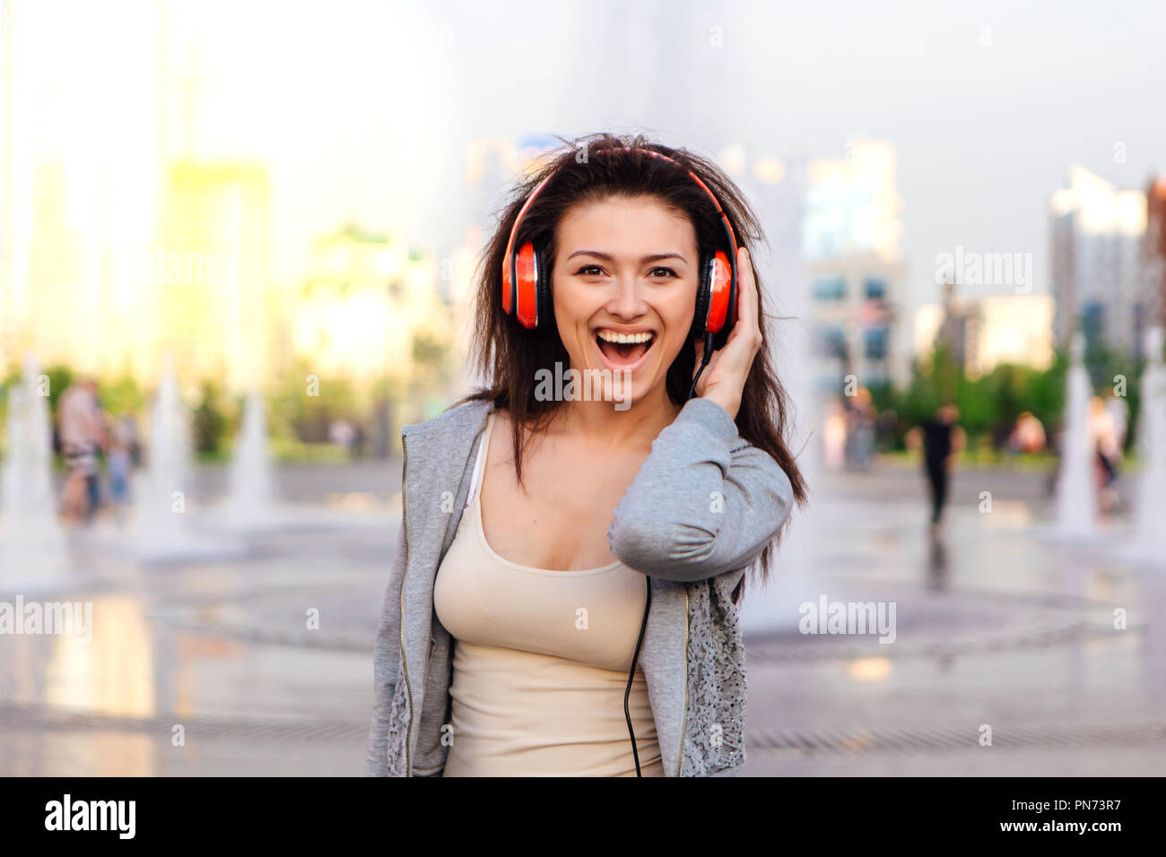 Young beautiful brunette woman listening to music streaming with ...