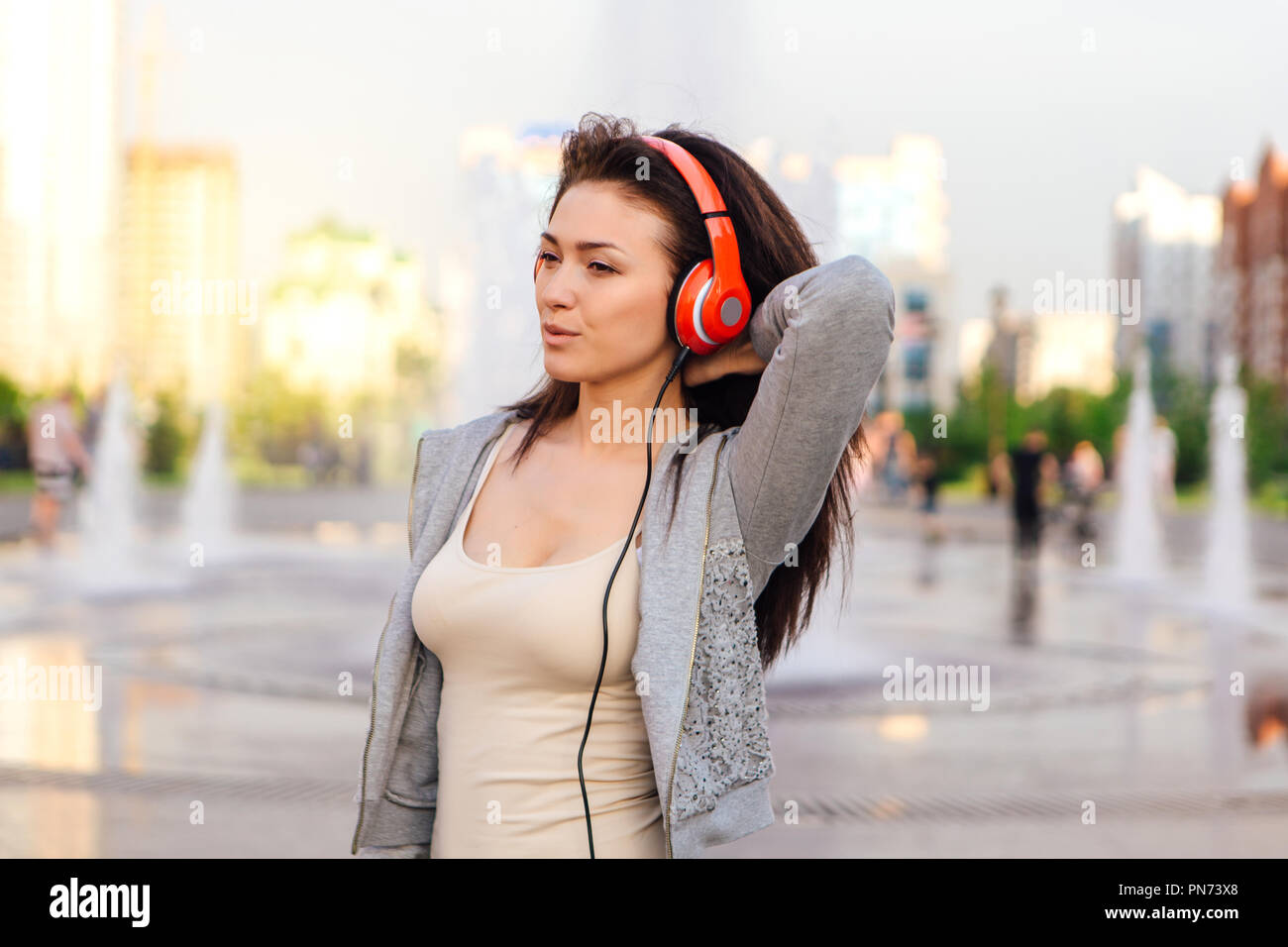 Young beautiful brunette woman listening to music streaming with ...