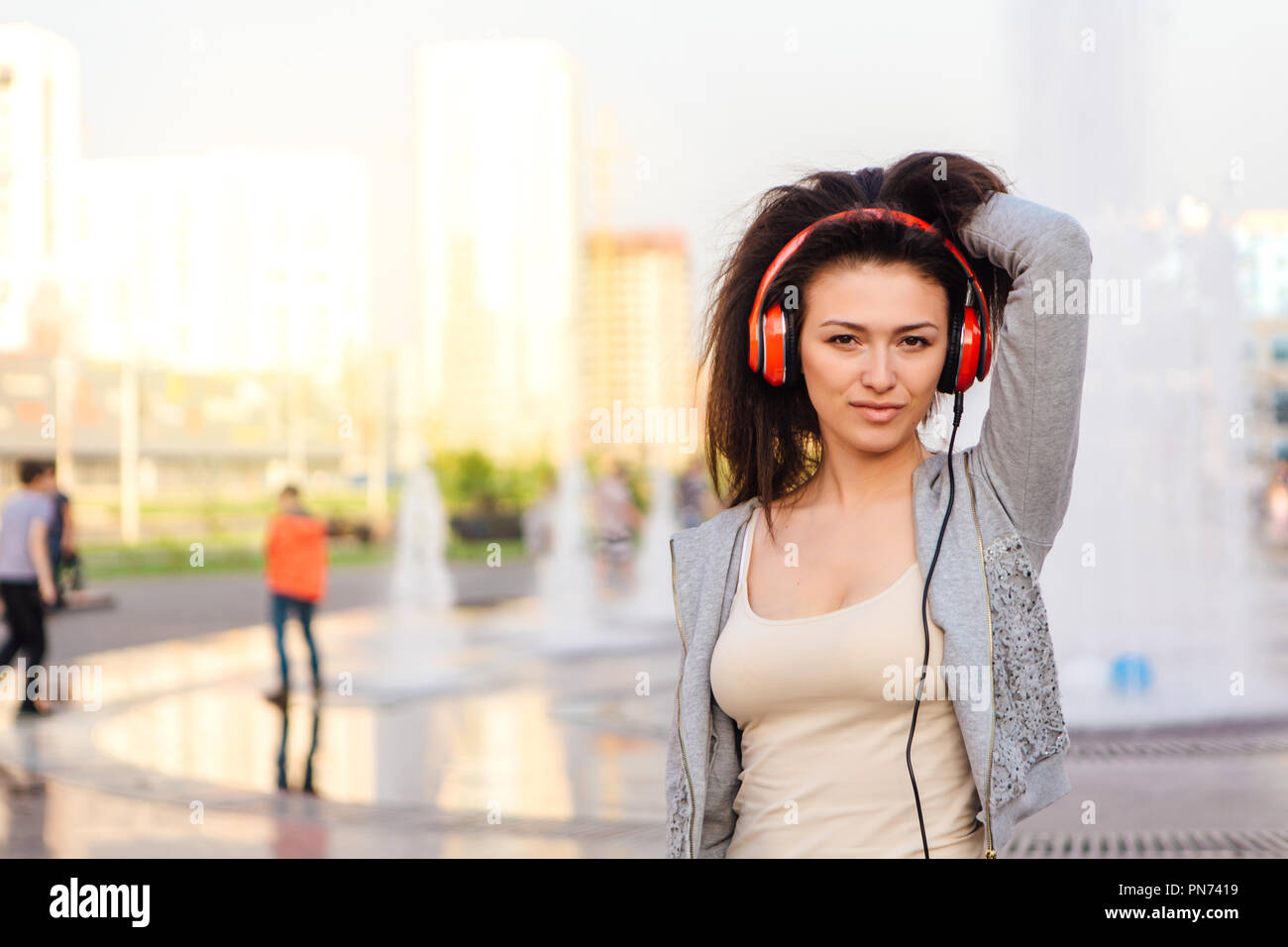 Young beautiful brunette woman listening to music streaming with ...