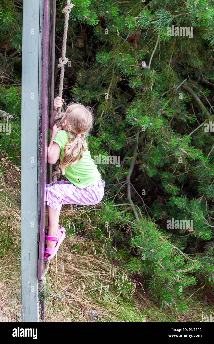 Little girl having fun outdoors at the climbing rope Stock Photo - Alamy