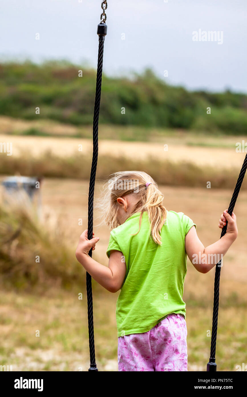 Little girl having fun standing on outdoor swing Stock Photo - Alamy