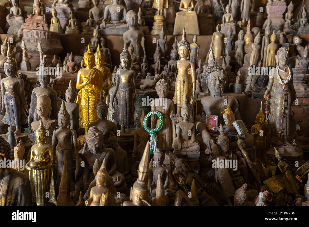 Close-up of hundreds of old and faded, golden and wooden Buddha statues ...