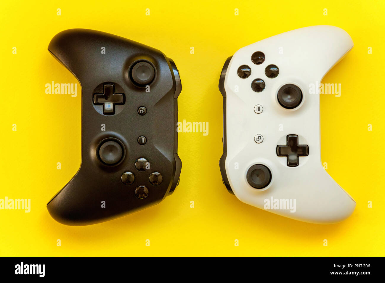White and black two joystick gamepad, game console on yellow colourful ...