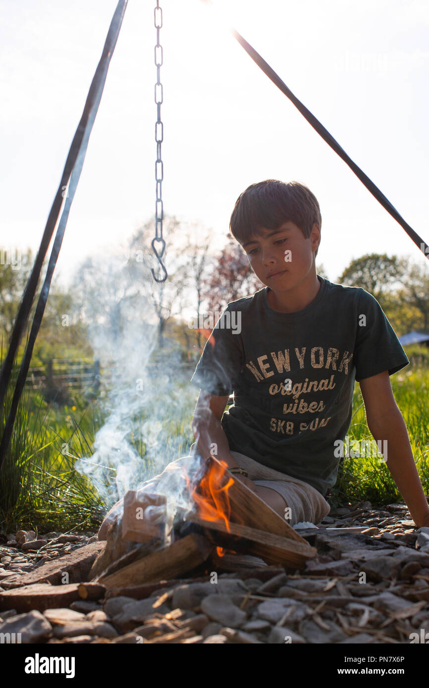 A young boy lighting a campfire Stock Photo - Alamy
