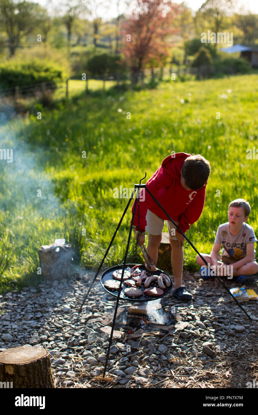 A young boy cooking on an open camp fire Stock Photo - Alamy