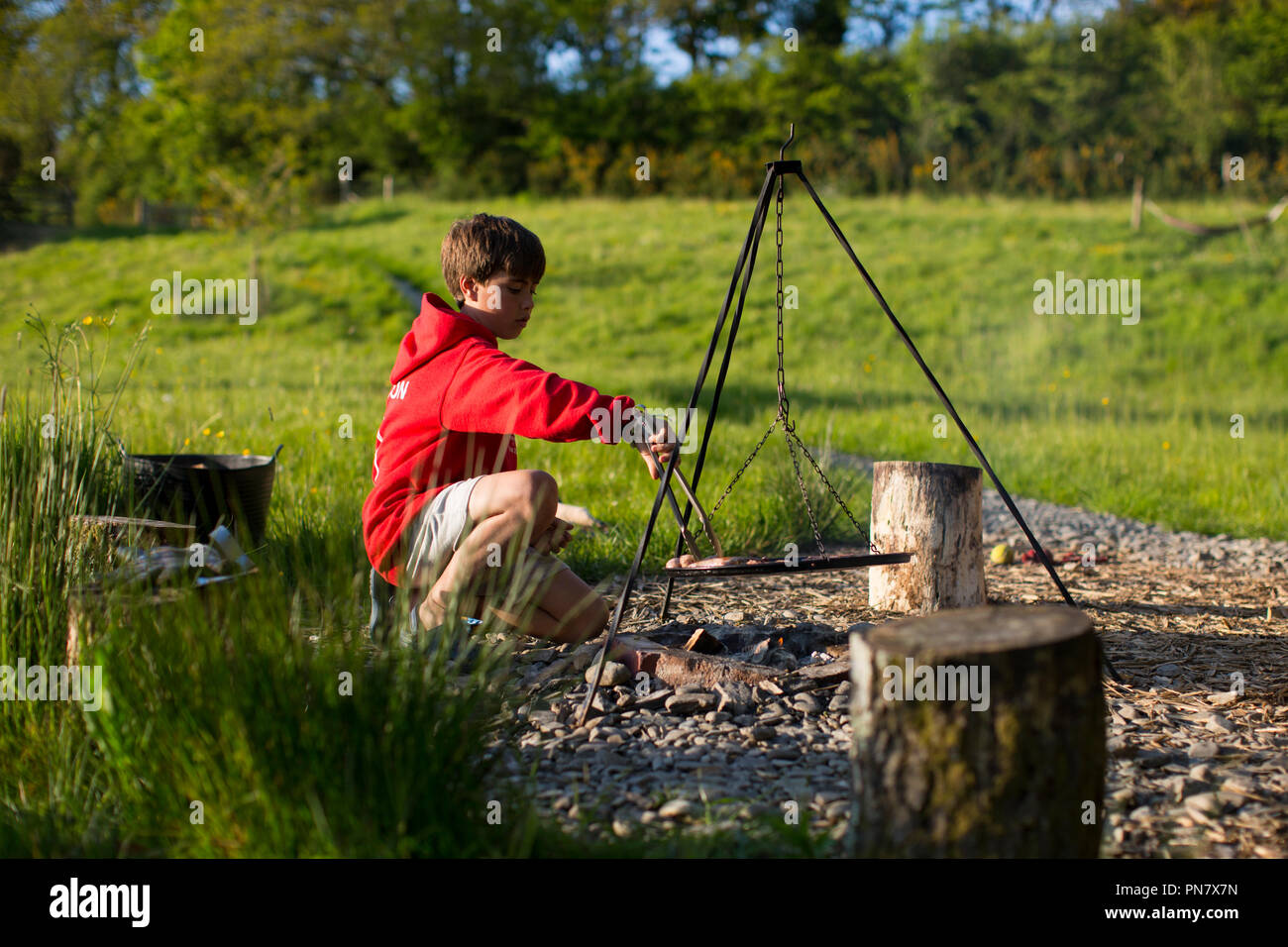 A young boy cooking on an open camp fire Stock Photo - Alamy