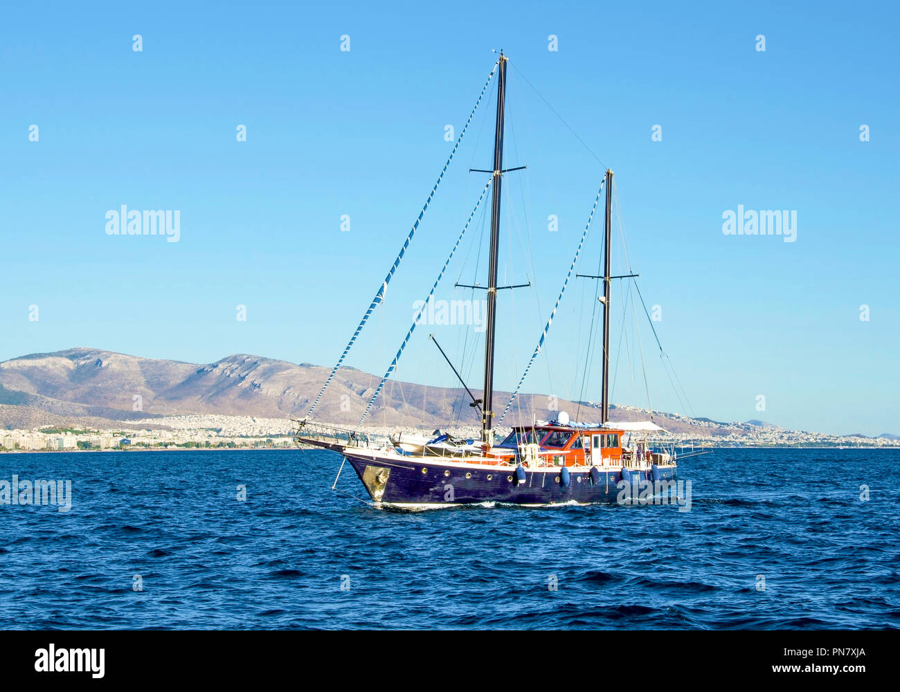 A nice beautiful wooden hull floating in blue waters of Saronic gulf ...