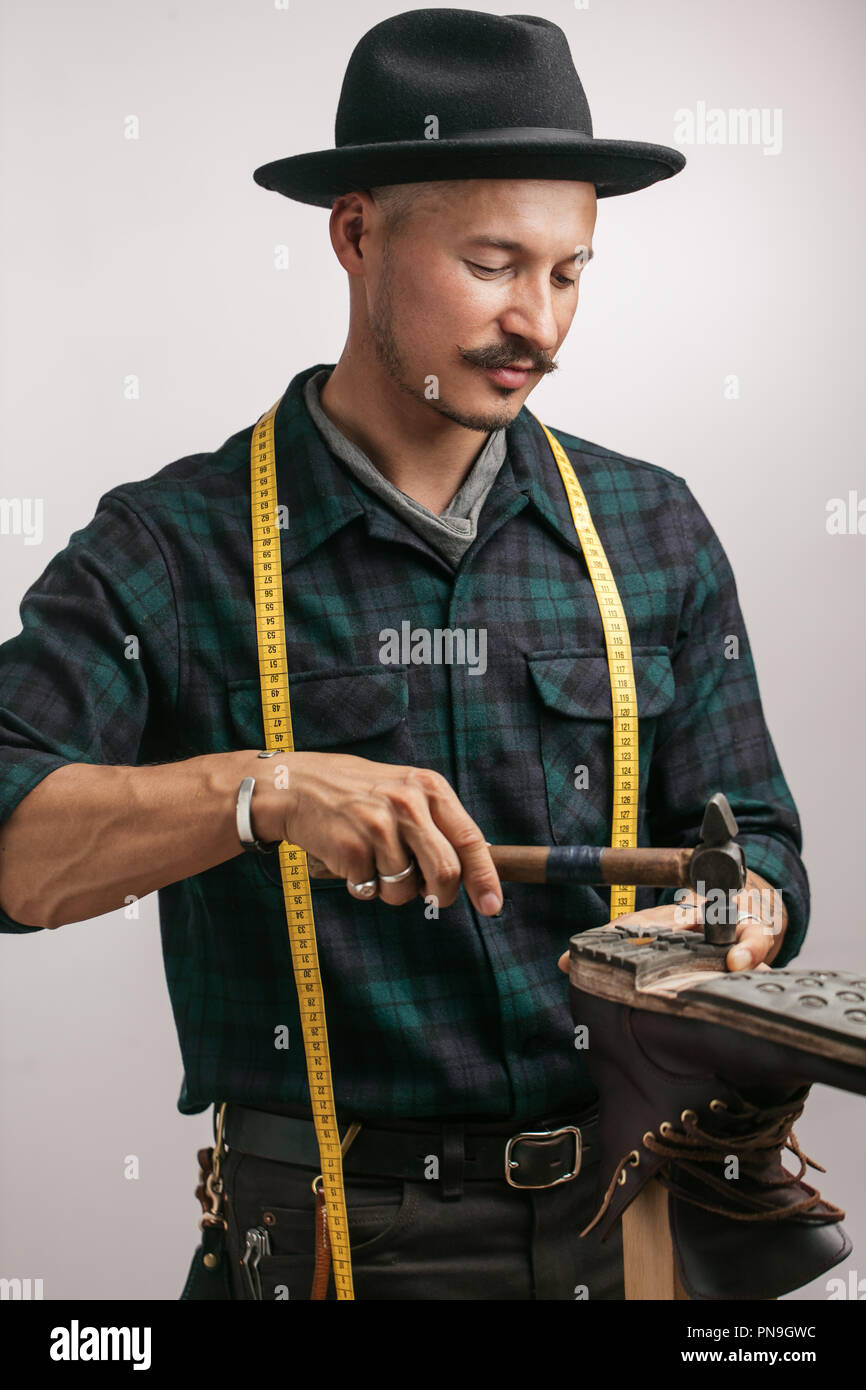 Shoemaker in studio. Unrecognizable shoemaker performs shoes in the ...