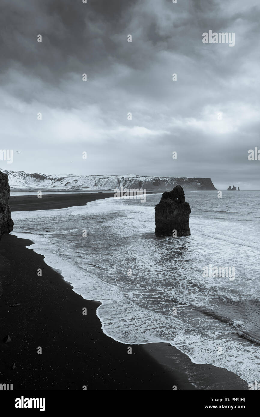 Reynisdrangar basalt sea stacks (troll rocks) and black volcanic sand ...