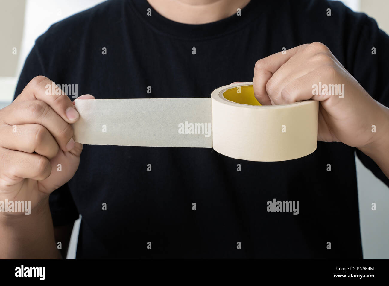Close up of a man packaging tape roll adhesive tap Stock Photo - Alamy