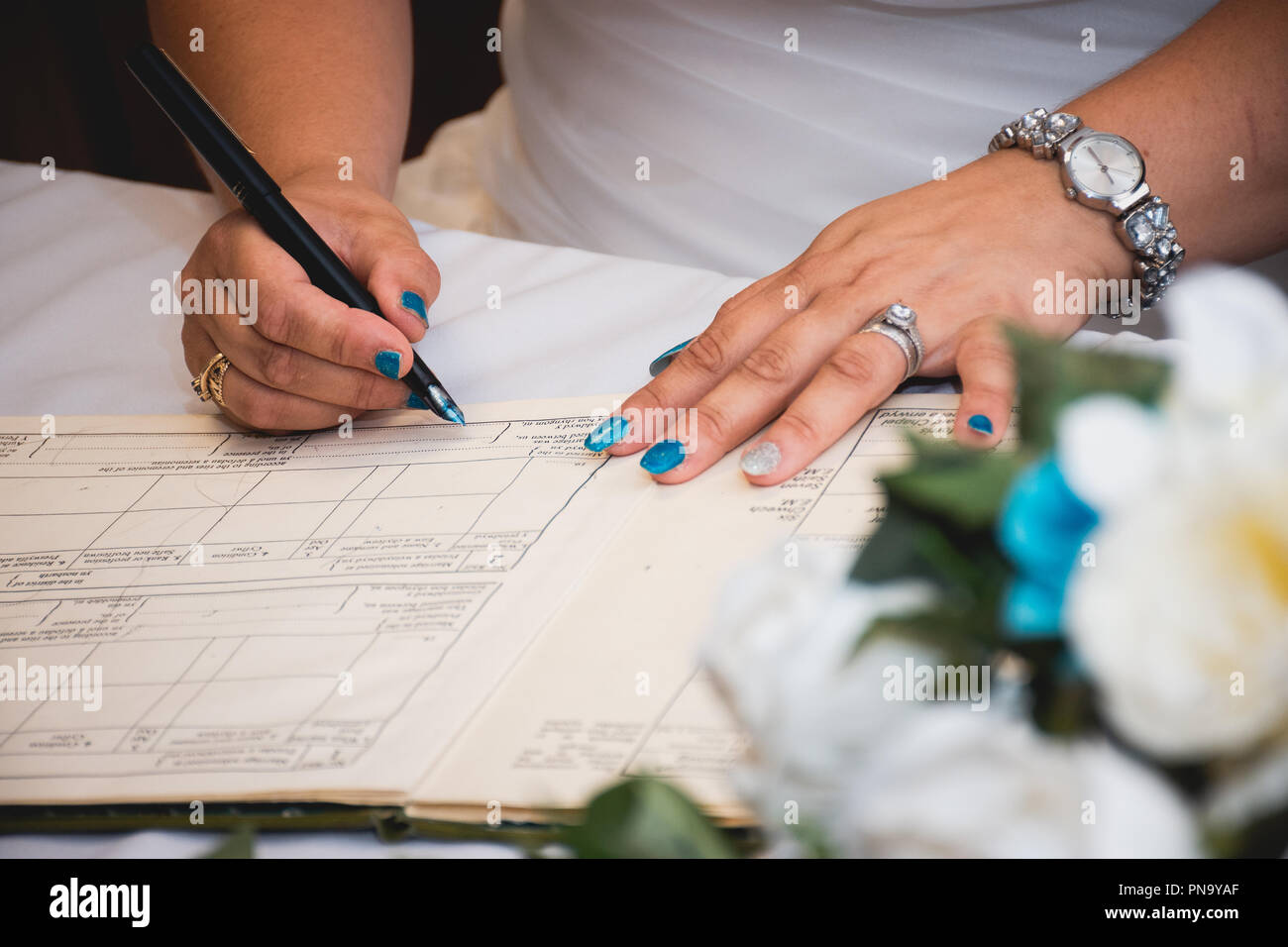 Bride signing the register on her wedding day Stock Photo - Alamy