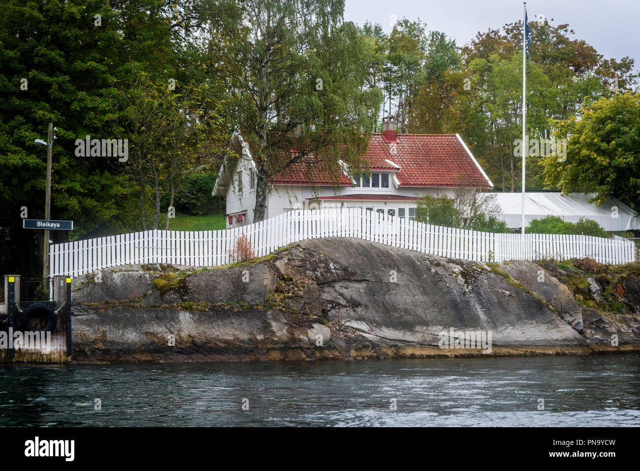 Residential house and white picket fence along cliff, Bleikøya island ...