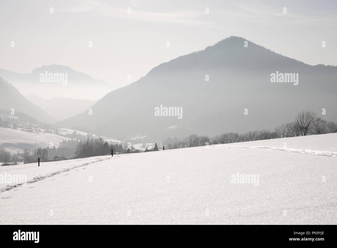 Snowy backlit mountain landscape in the french alps Stock Photo - Alamy