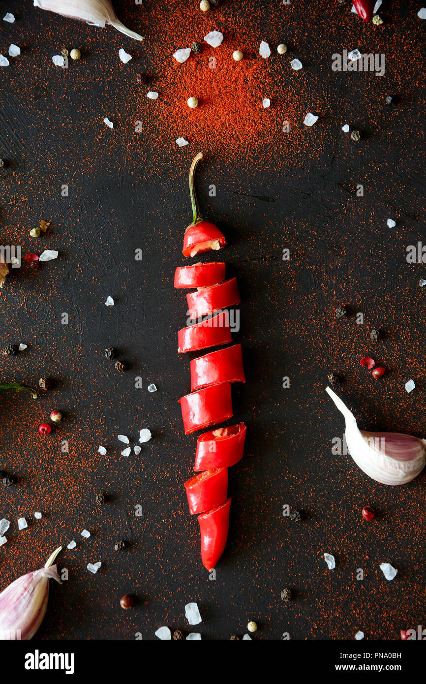 Sliced ripe red chili pepper, garlic, pods, peas and powder lying on ...
