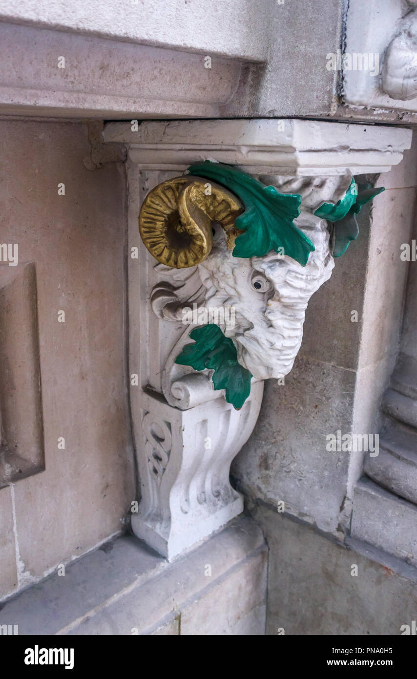 Architectural detail: stucco work ram's head with gilded horns on a ...