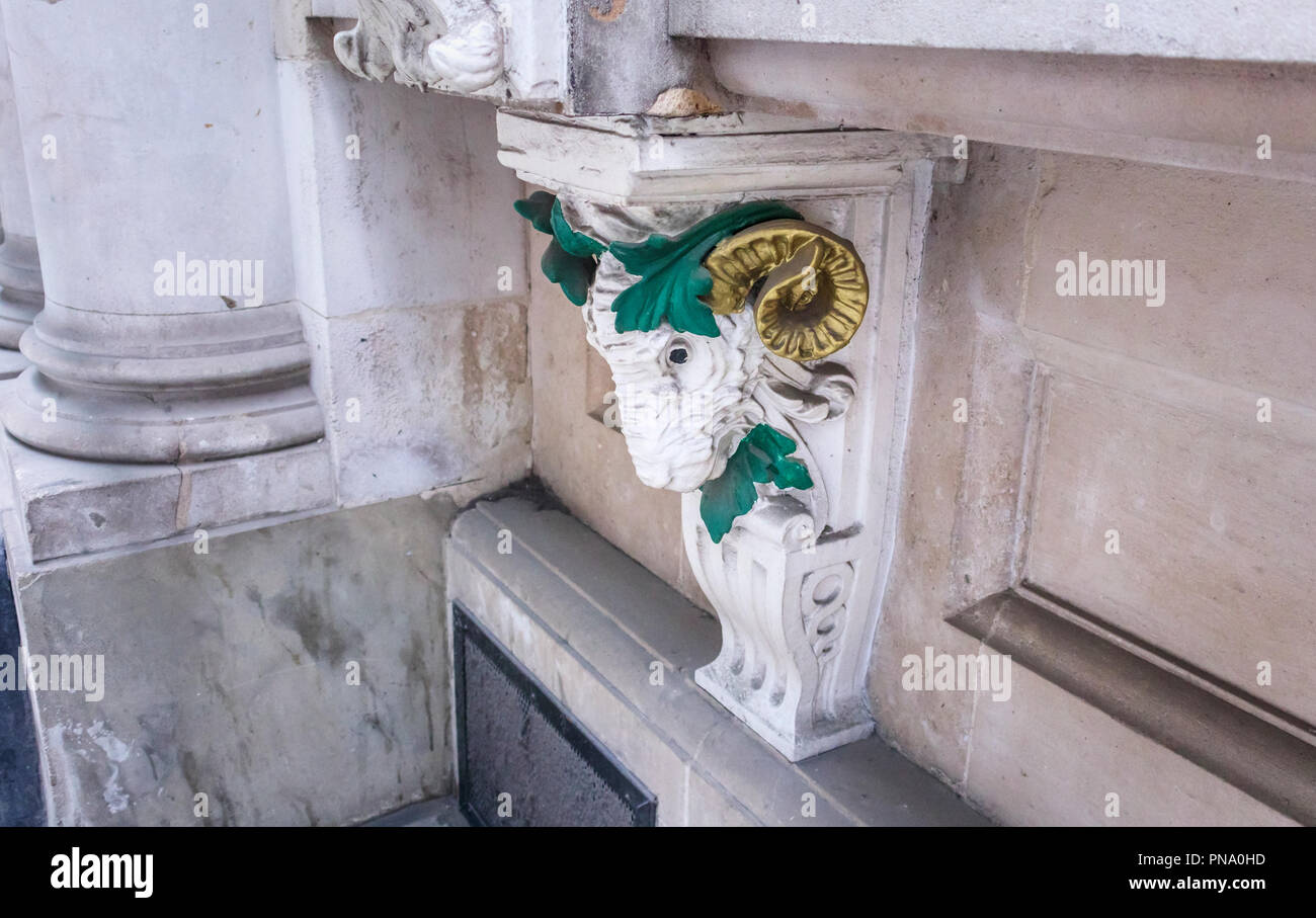 Architectural detail: stucco work ram's head with gilded horns on a ...