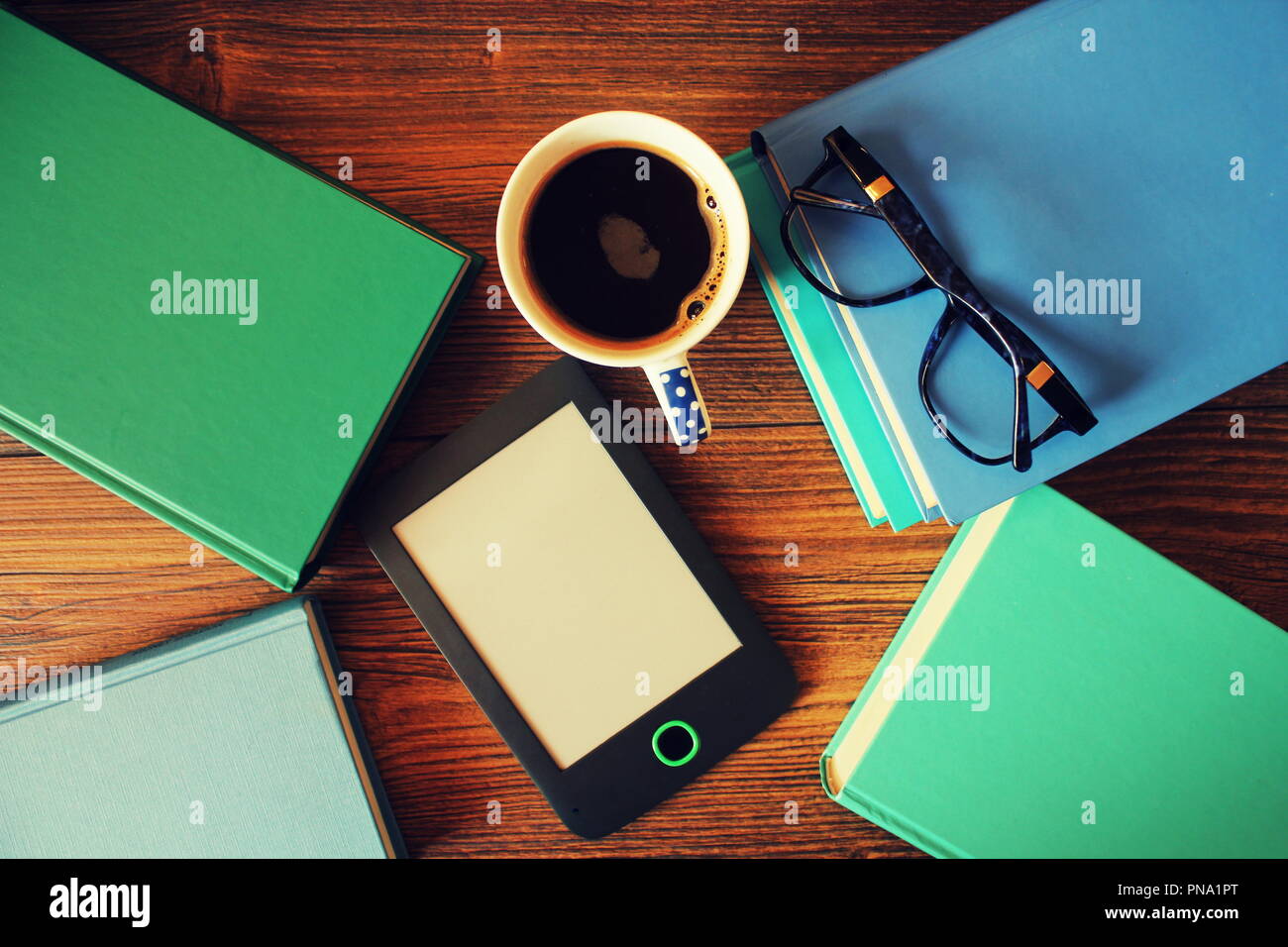 E-book reader and books on wooden background .Education background ...