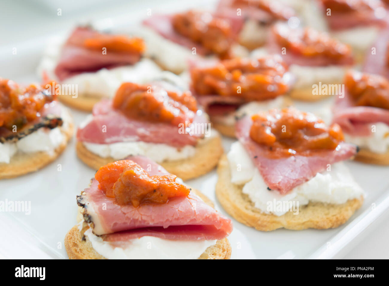 Canape with smoked meat, cheese and tomato sauce Stock Photo - Alamy
