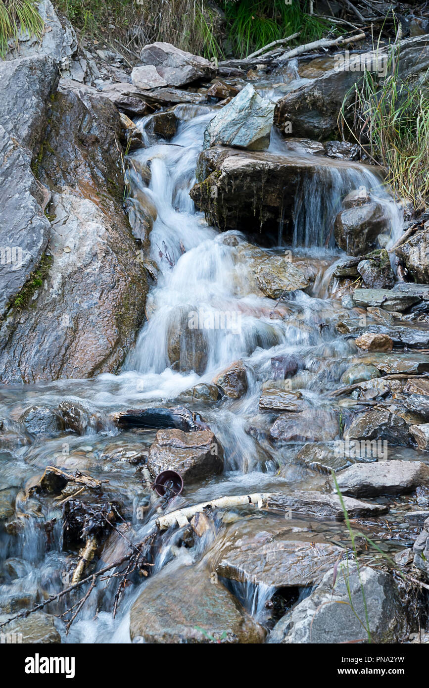 a small waterfall running down the rocks, cloudy weather Stock Photo ...