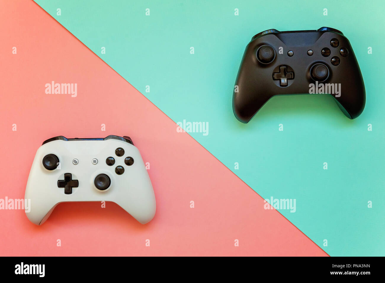 White and black two joystick gamepad, game console on pink and blue ...