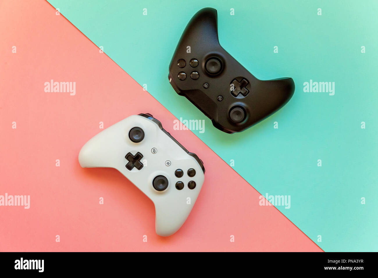 White and black two joystick gamepad, game console on pink and blue ...