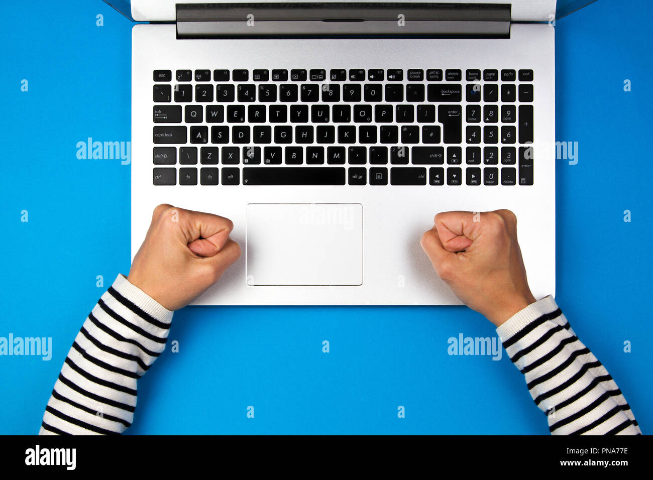 Clenched fists hitt laptop keyboard on blue background hit fist Stock ...