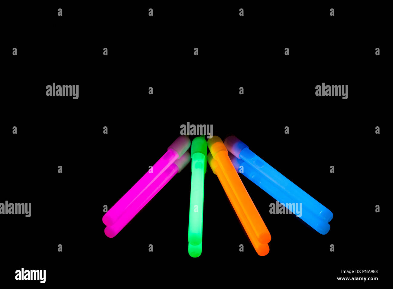 Colorful fluorescent light neon glow stick on mirror reflection black ...