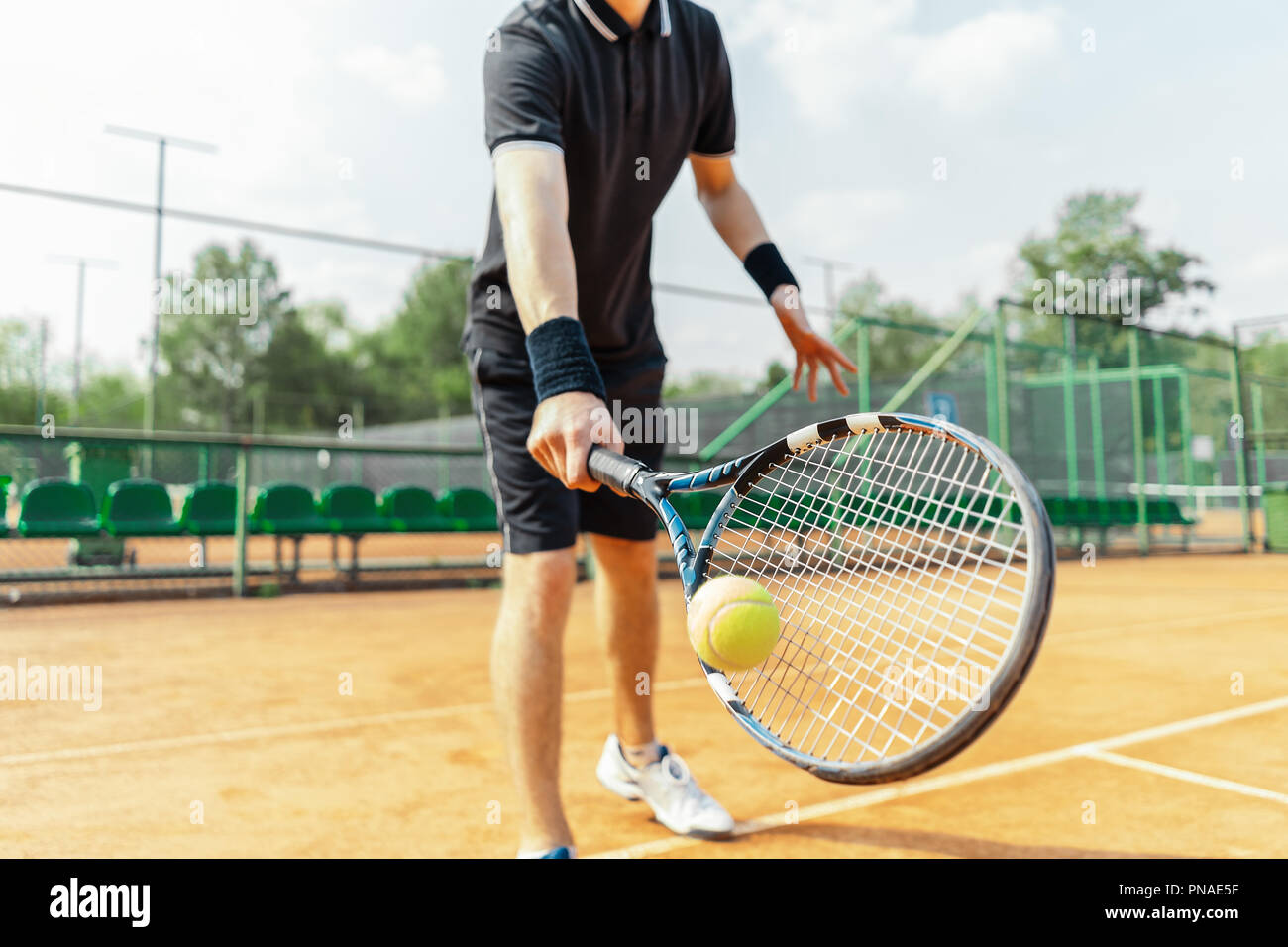 Close up of young attractive man playing tennis at tennis court. Player ...