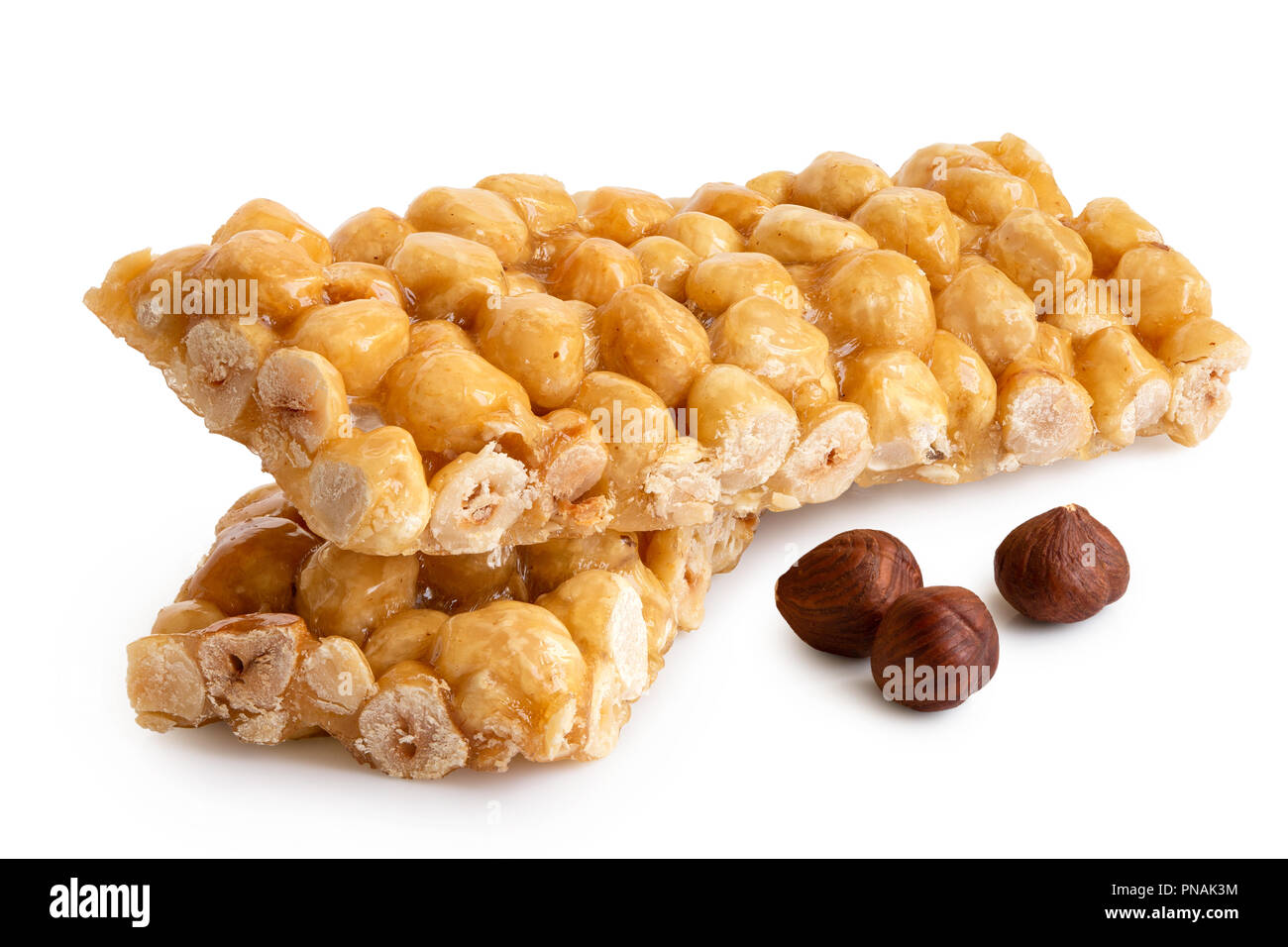 Two hazelnut snack bars isolated on white. Three shelled hazelnuts ...