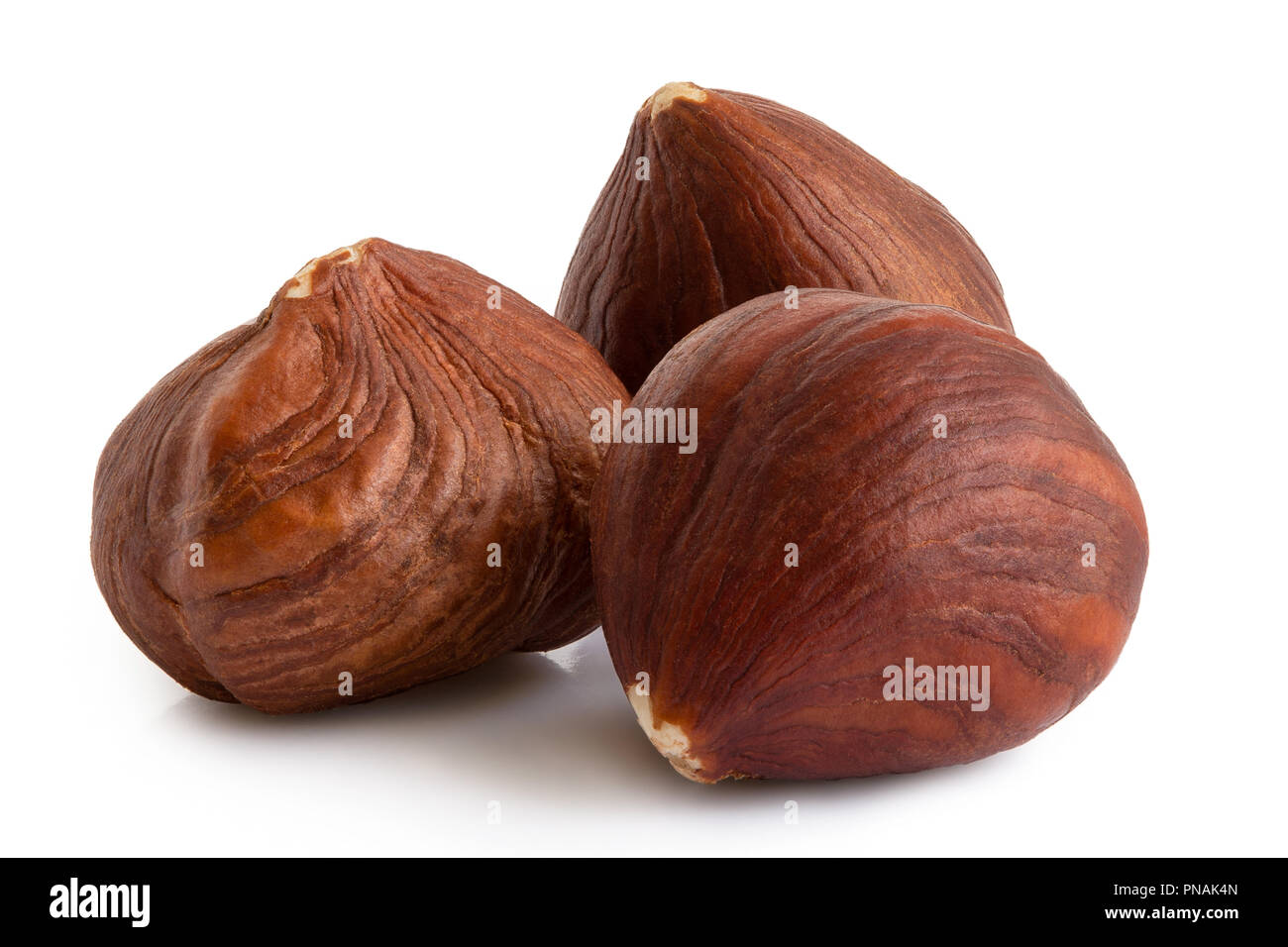 Three hazelnuts with skin isolated on white. Closeup Stock Photo - Alamy