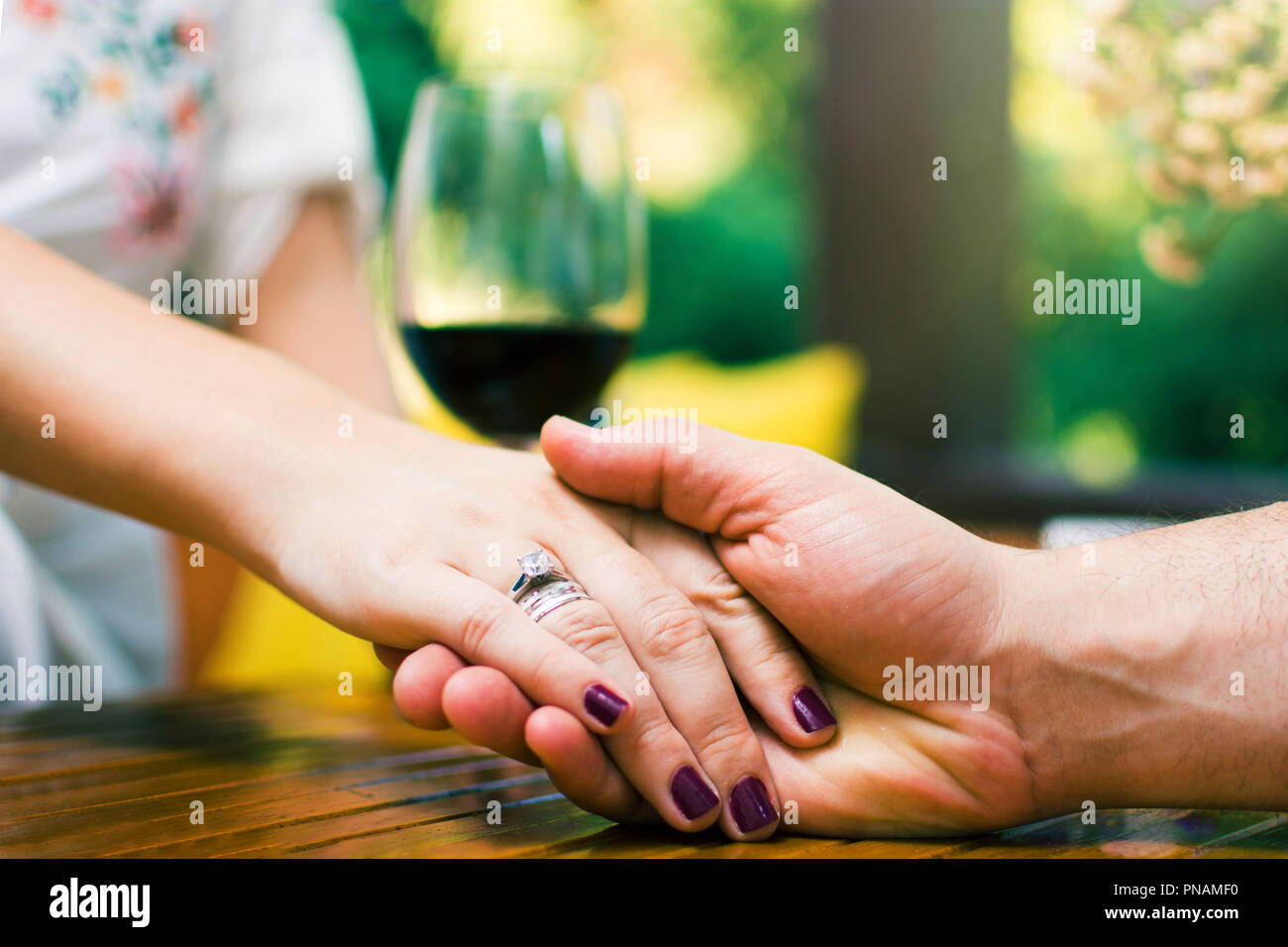 Engaged couple holding hands restaurant hi-res stock photography and ...