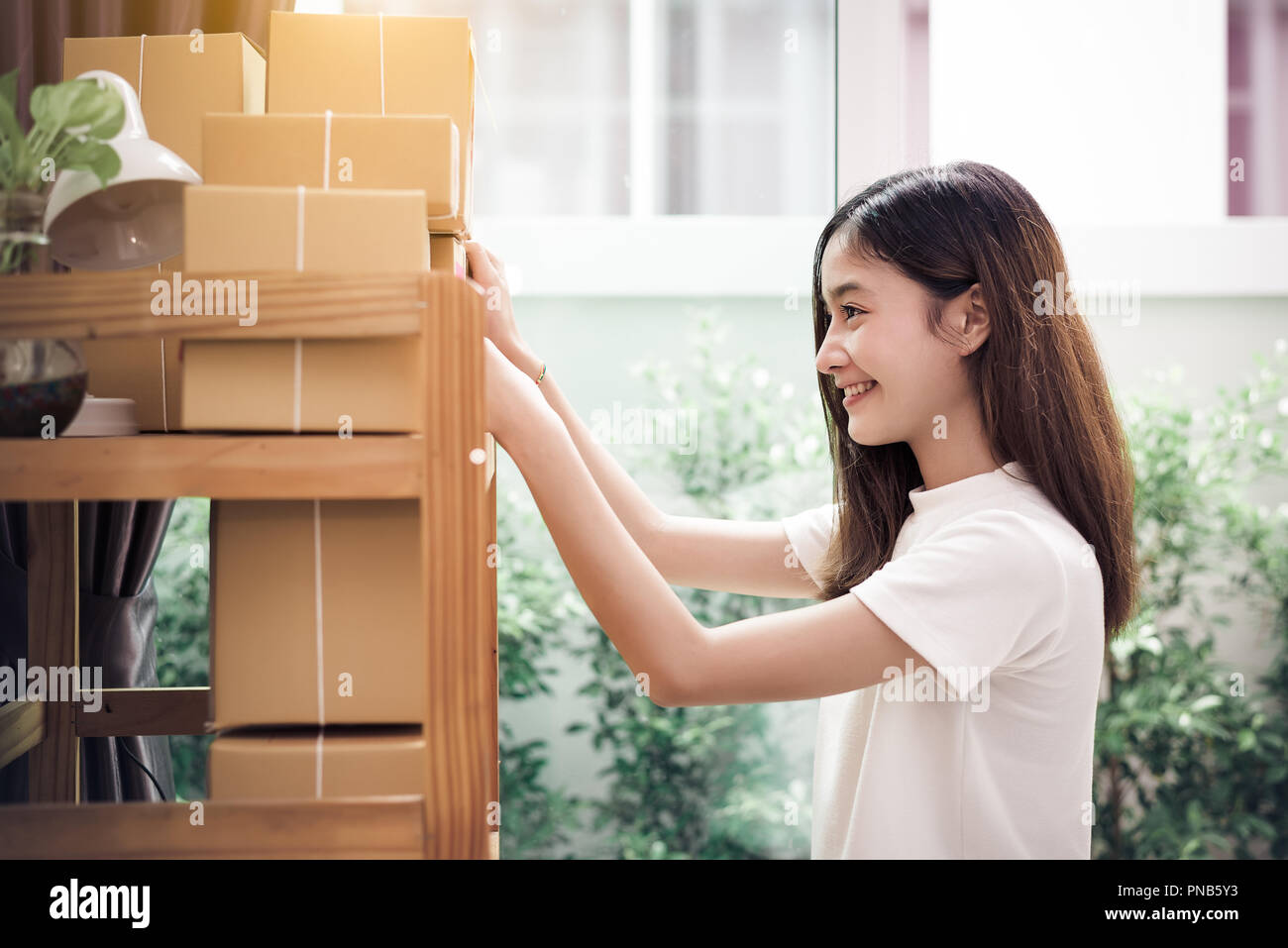 Asian woman put sticky memo paper note on parcel mail box and ready to ...