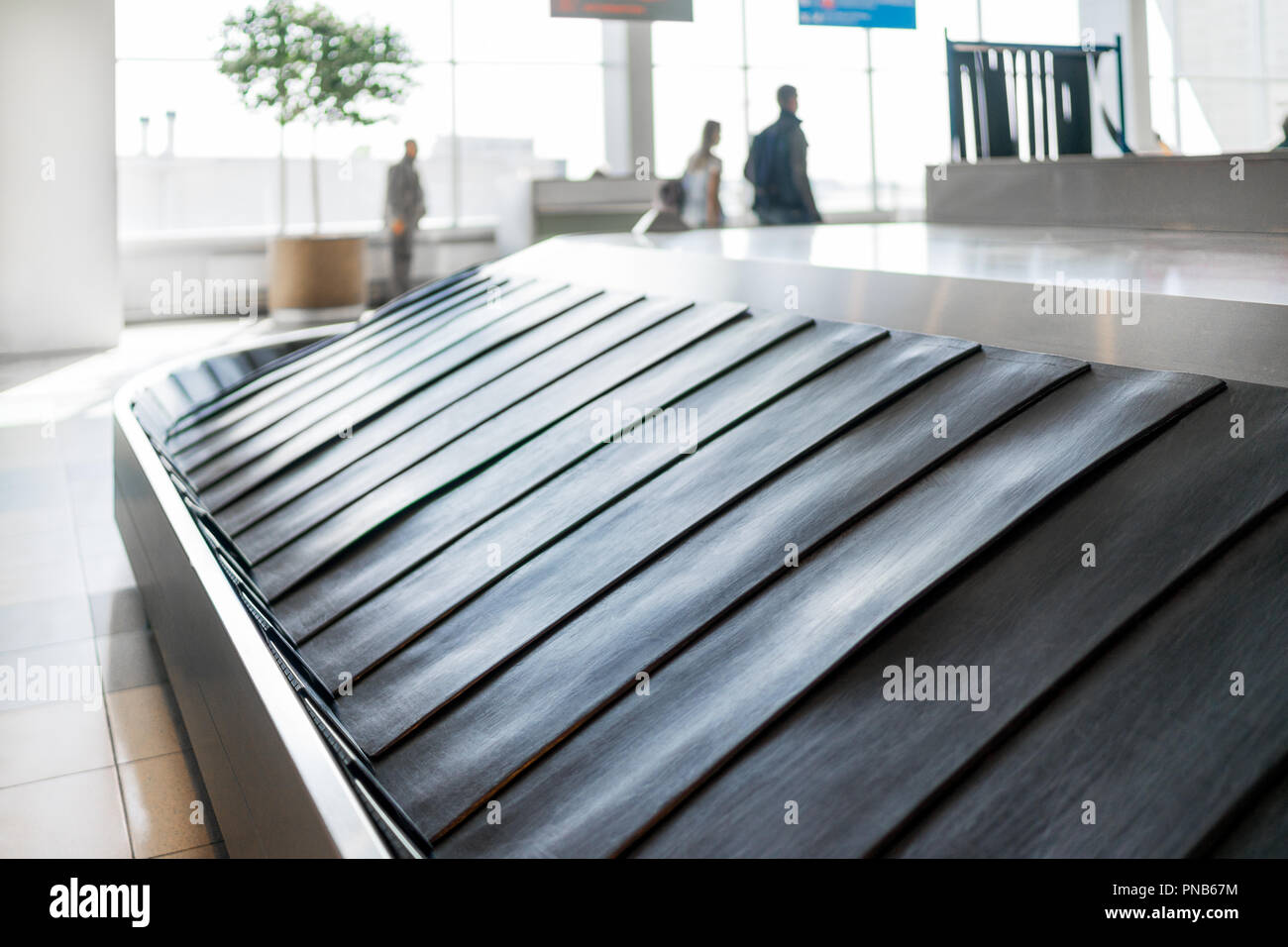 A rotating black rubber airport baggage claim carousel (conveyor belt ...