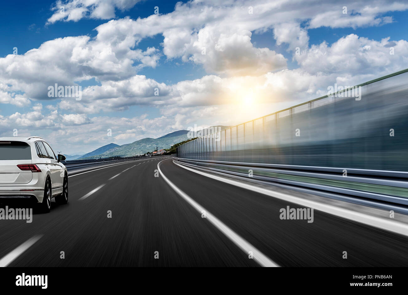 A white car rushing along a high-speed highway in the sun Stock Photo ...