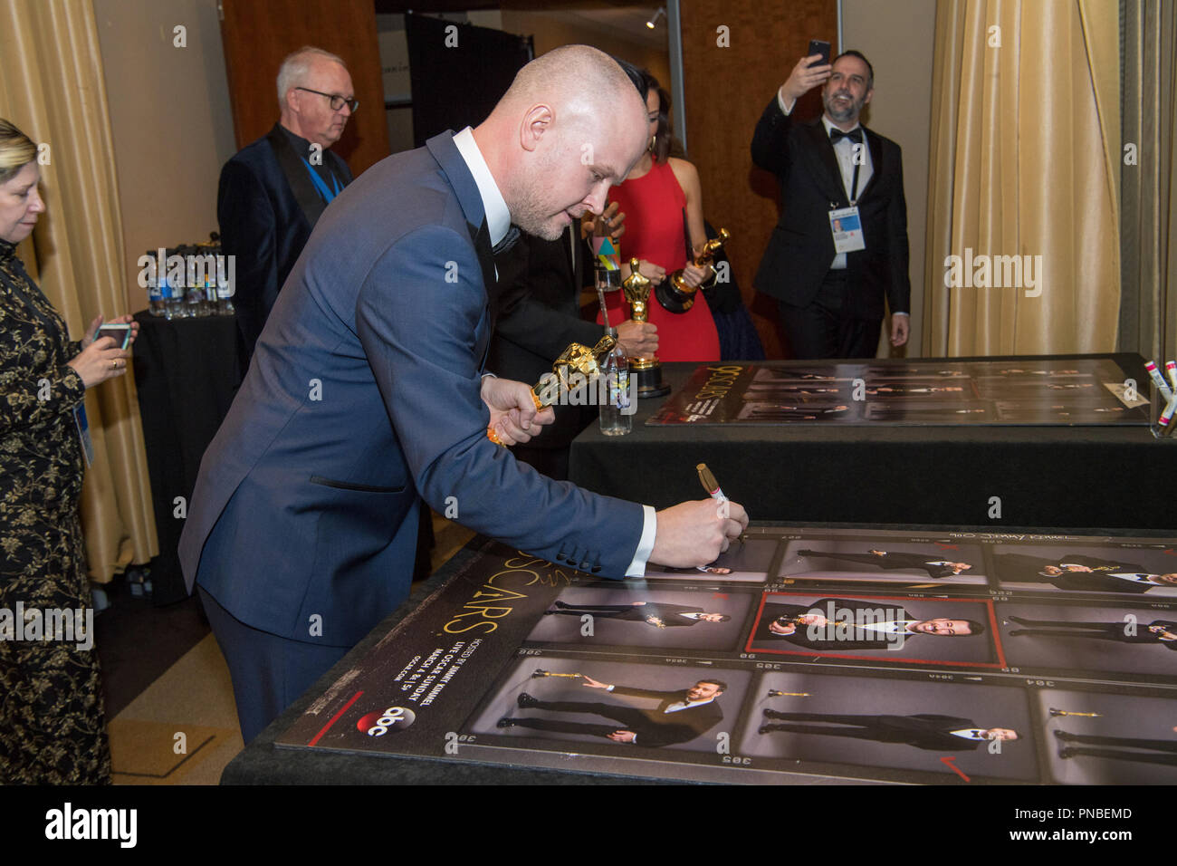 David Malinowski signs a poster backstage with the Oscar® for ...