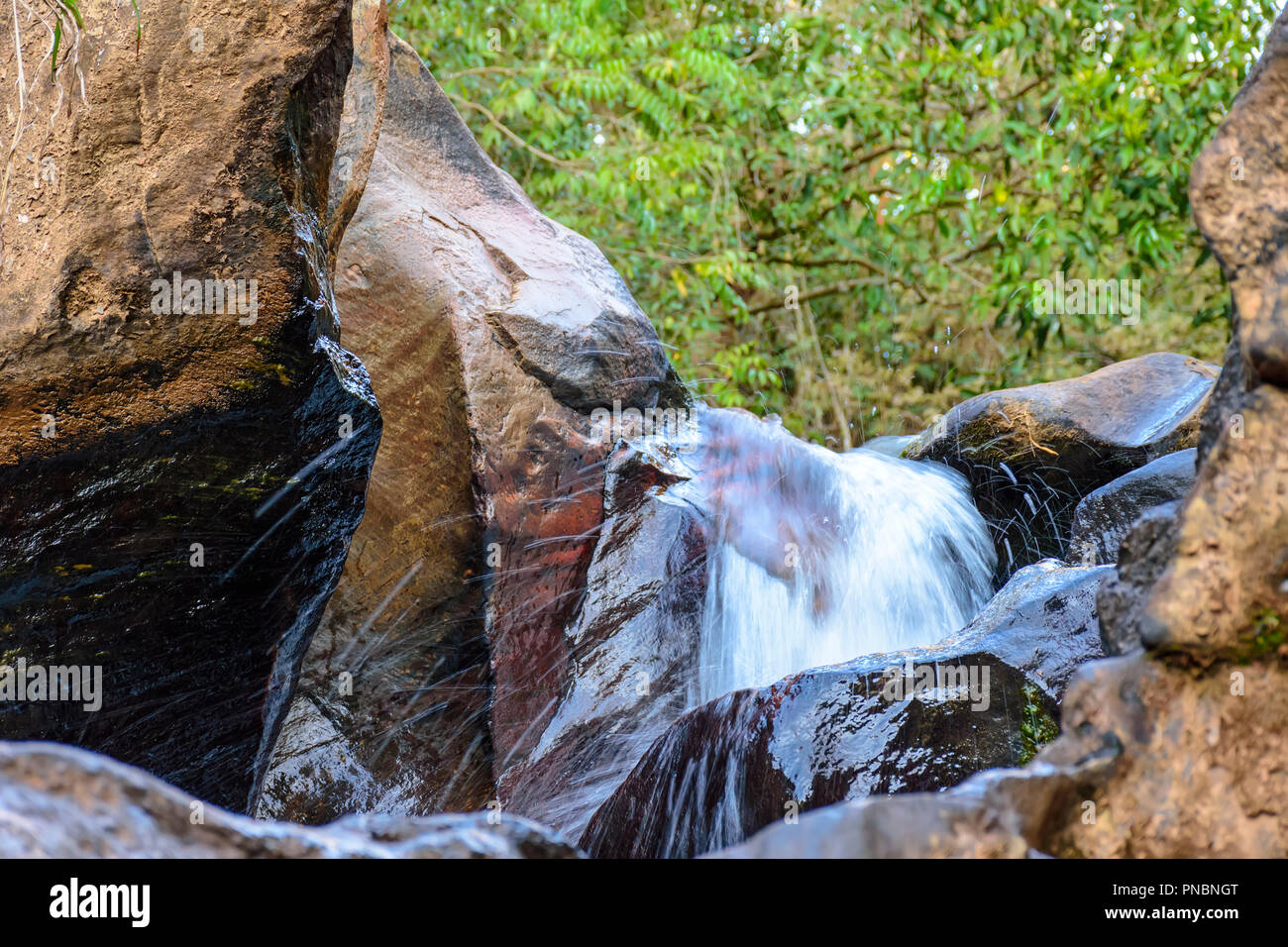 Small cascade with clear and limpid waters running through the rocks of ...